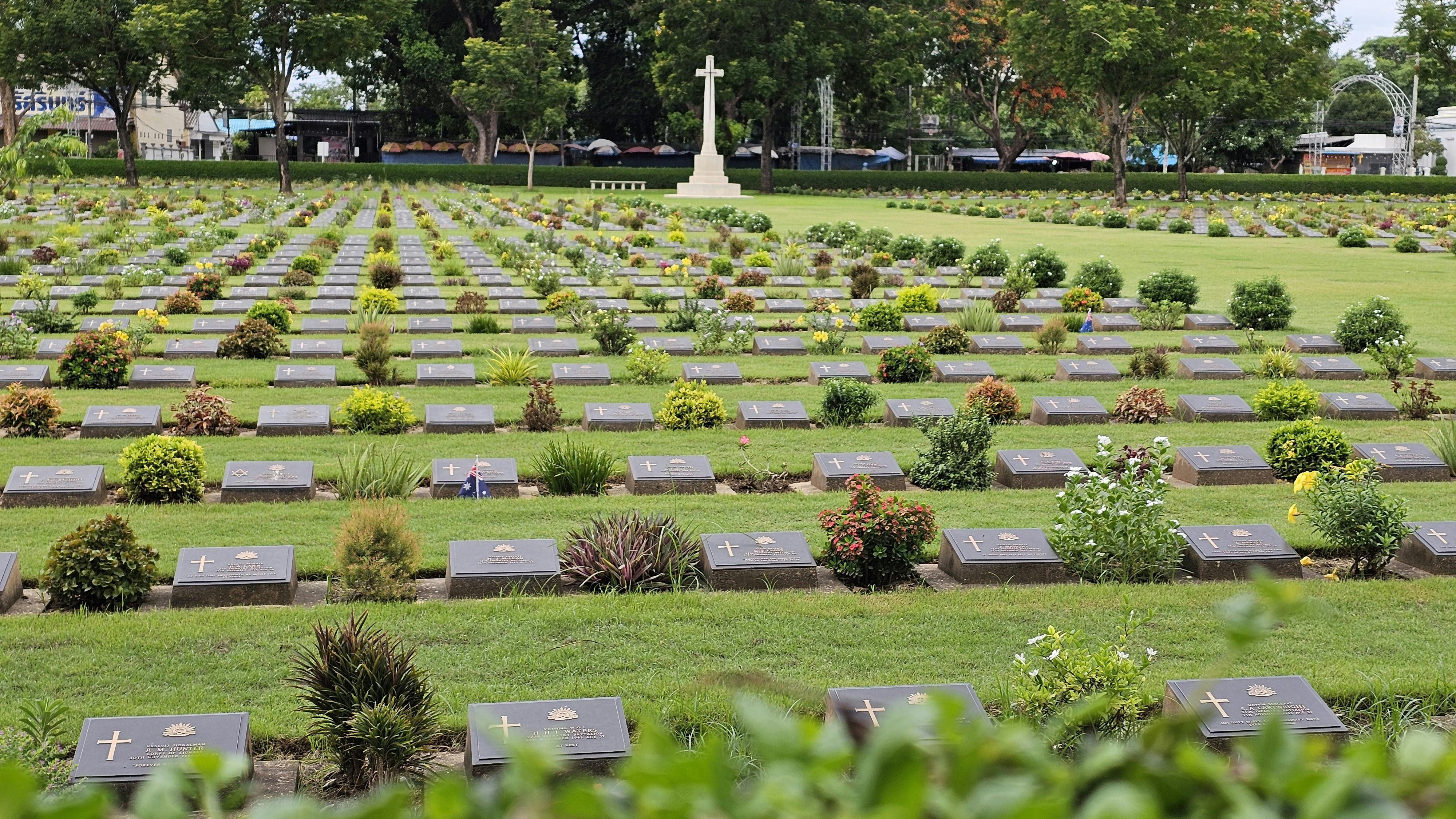 A cemetery with rows of graves and trees · Free Stock Photo