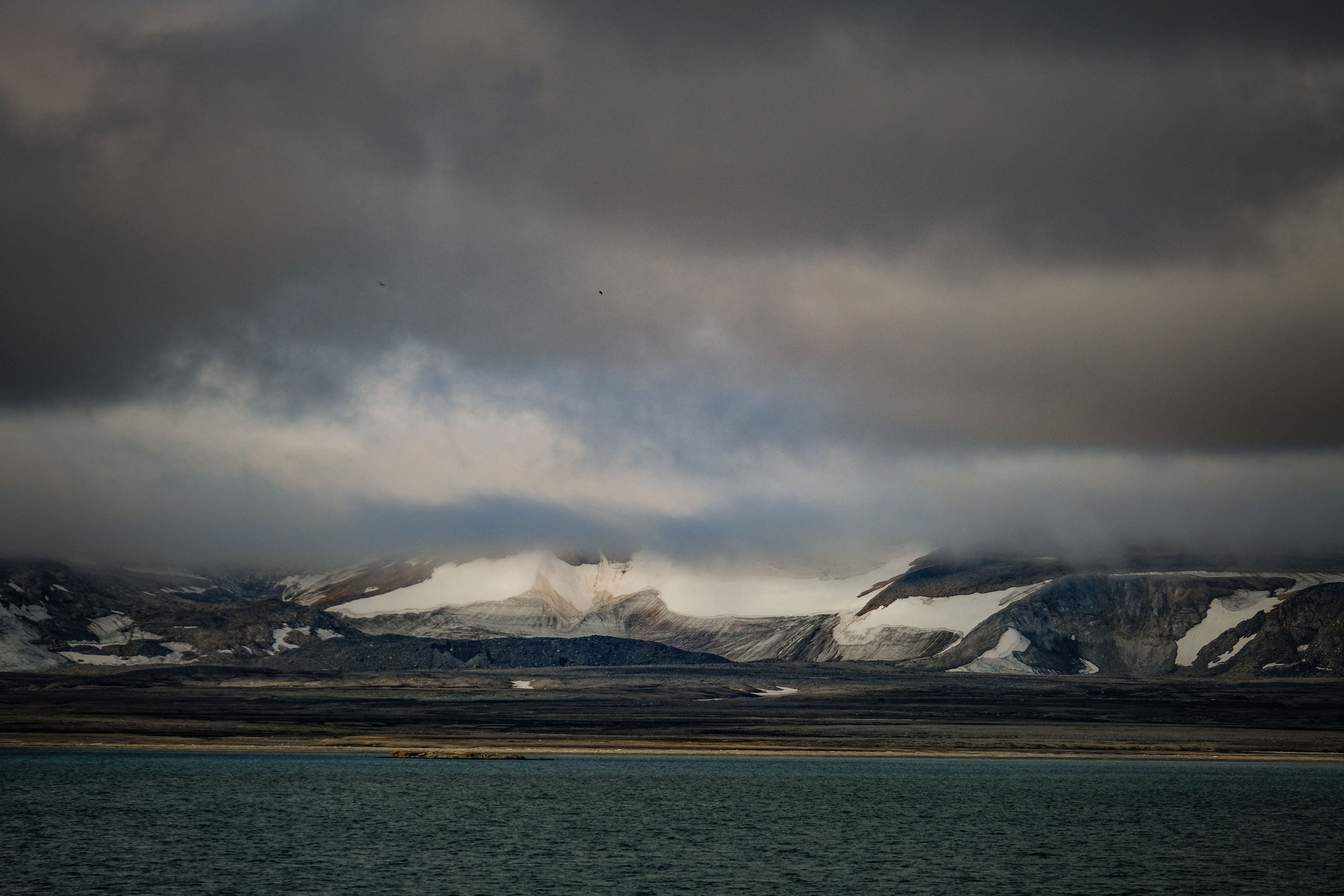 Sea Coastline and Hills under Storm Cloud · Free Stock Photo