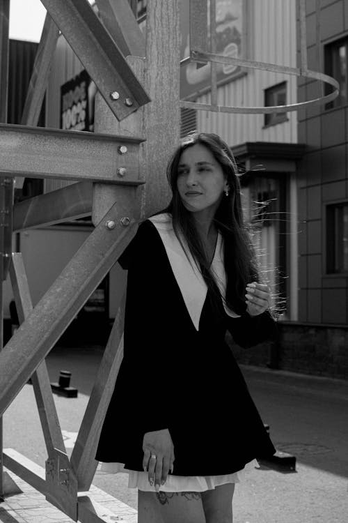 Portrait Of A Young Woman In Black Mini Dress Standing In Front Of A Building Black And White
