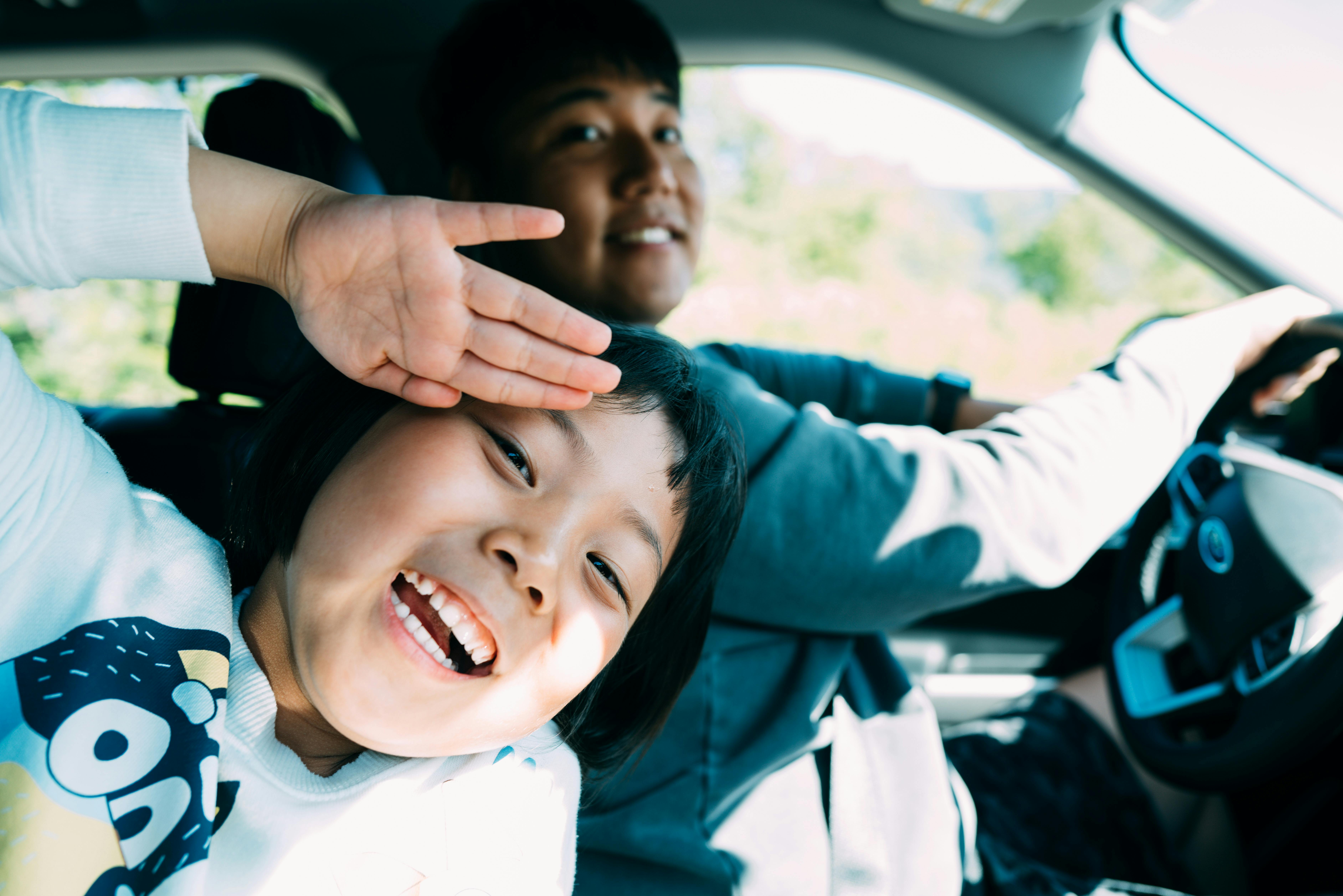 Child Sitting in a Car Saluting towards the Camera · Free Stock Photo