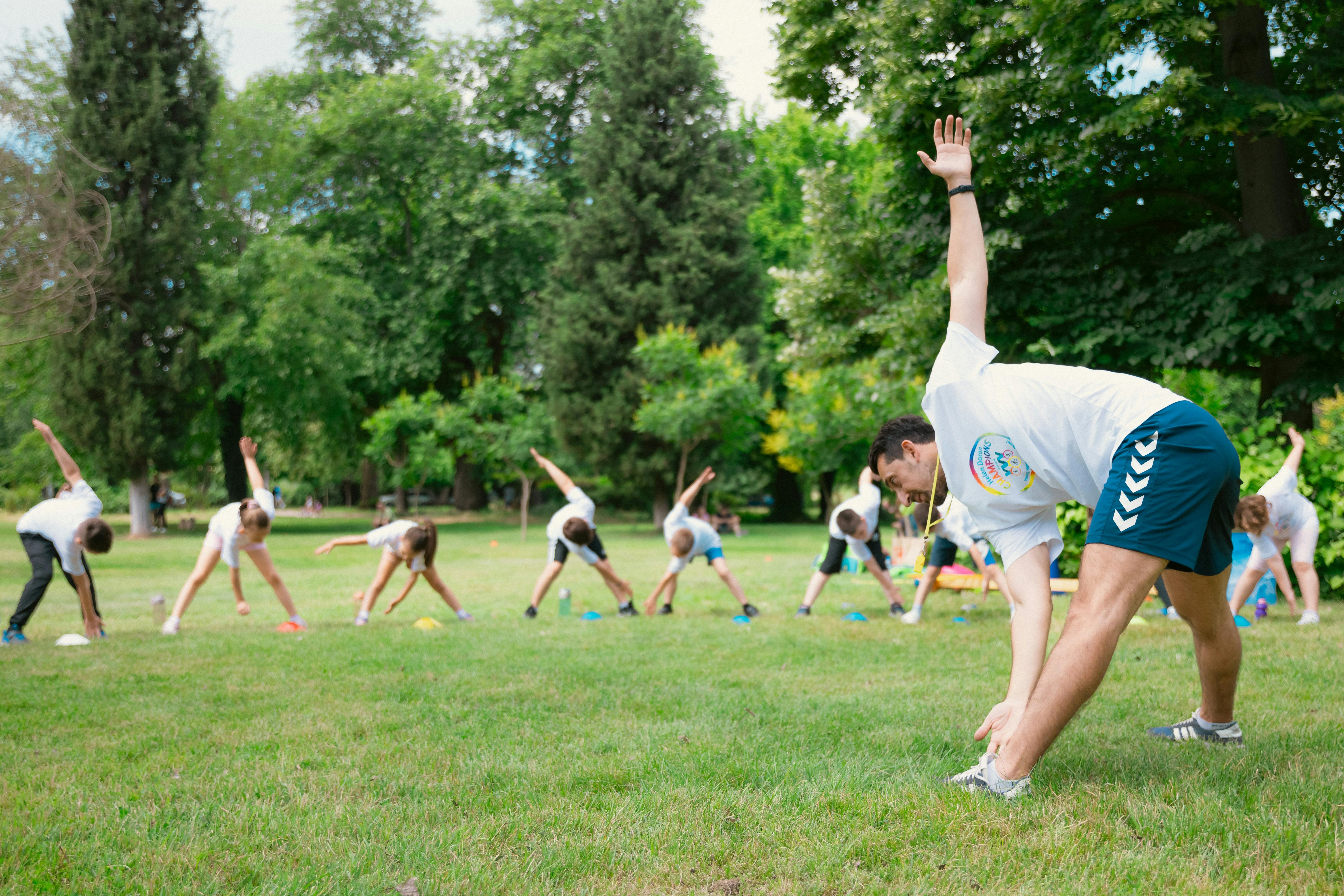Schoolchildren Stretching on Grass during an Outdoor Physical Education ...