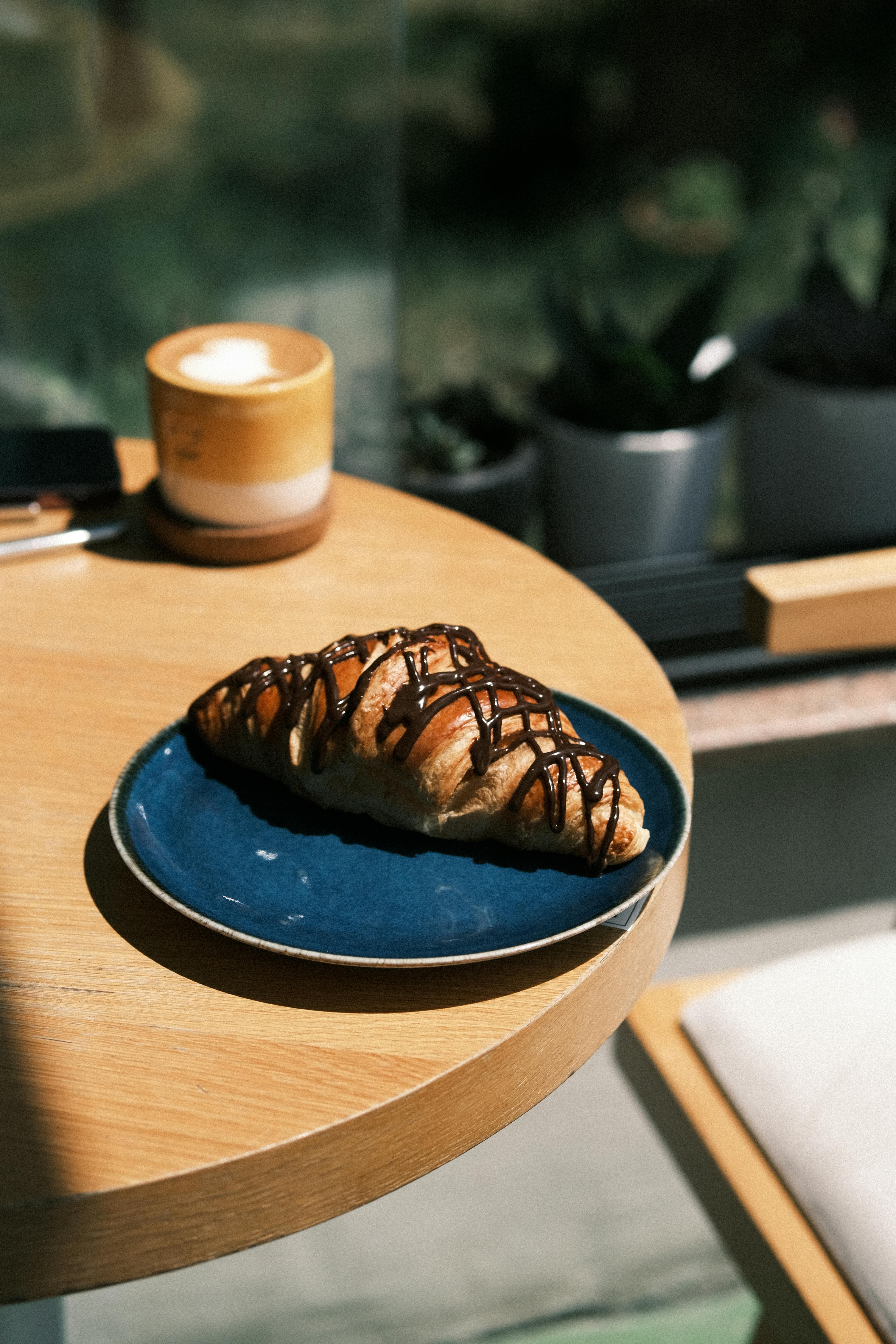 A Croissant with Chocolate and a Cup of Coffee Standing on the Table ...