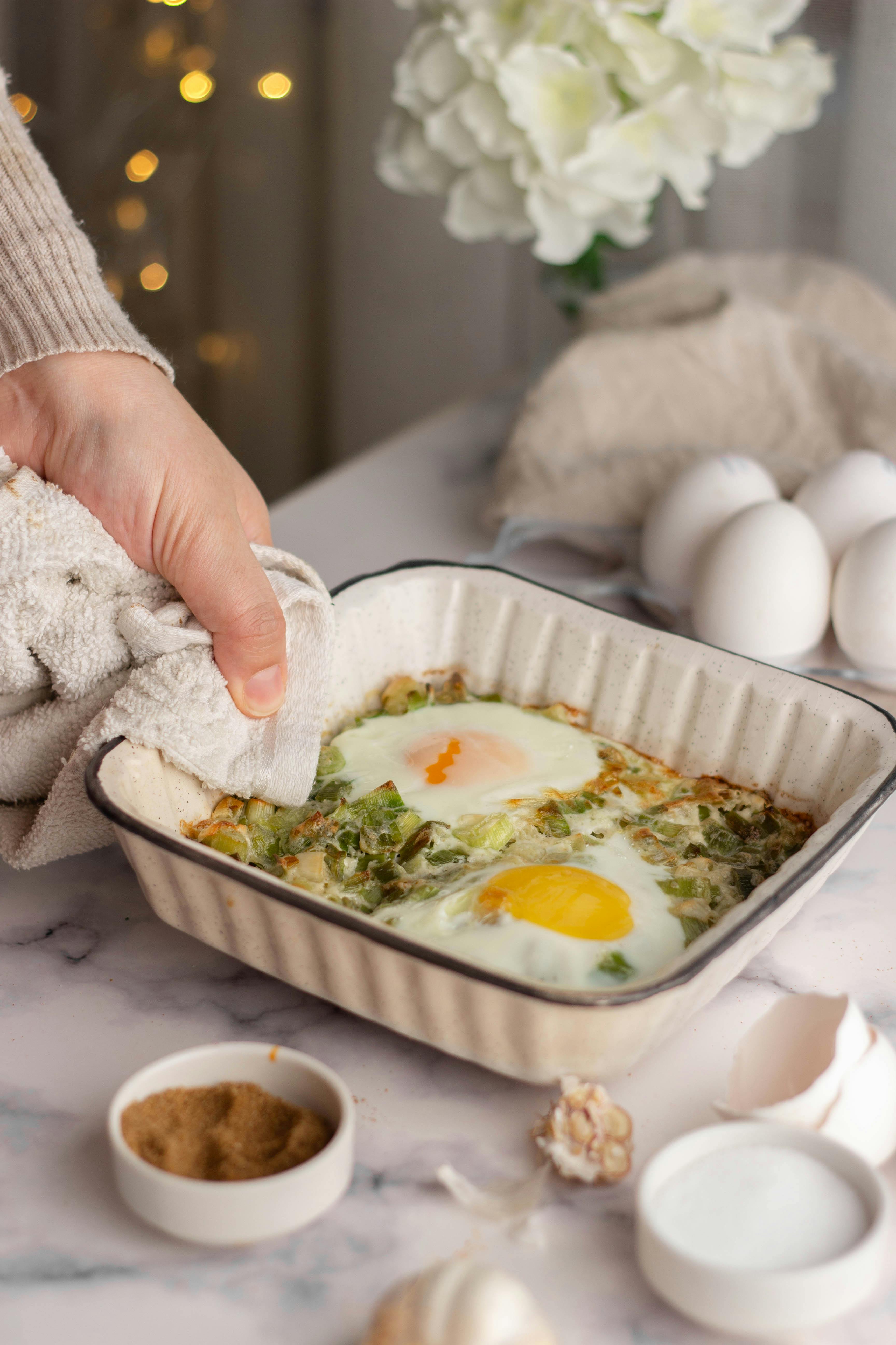 Hand of a Person Placing a Dish in a Baking Pan onto a Table · Free ...