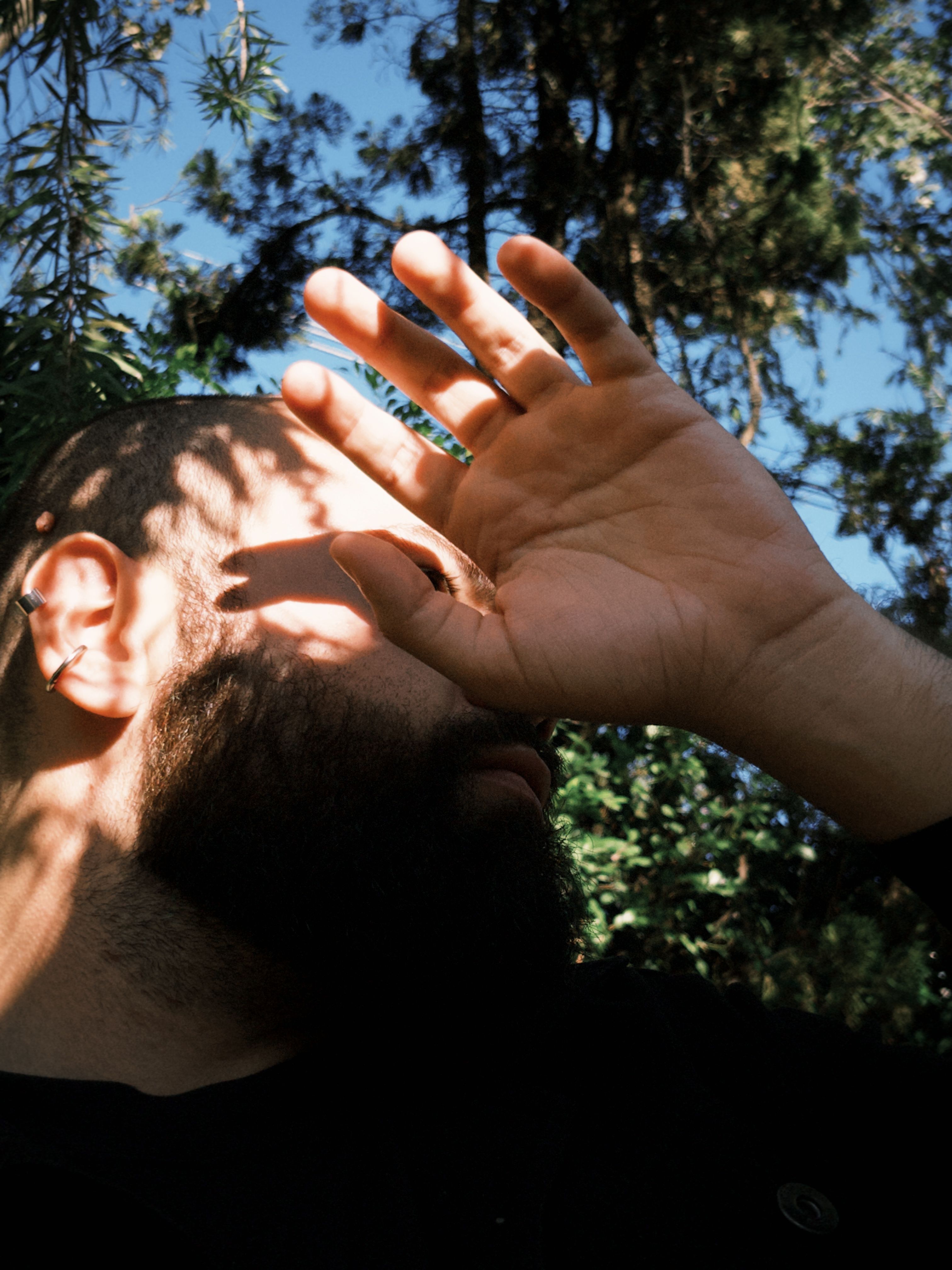 Man Protecting Face with Face from Sun · Free Stock Photo