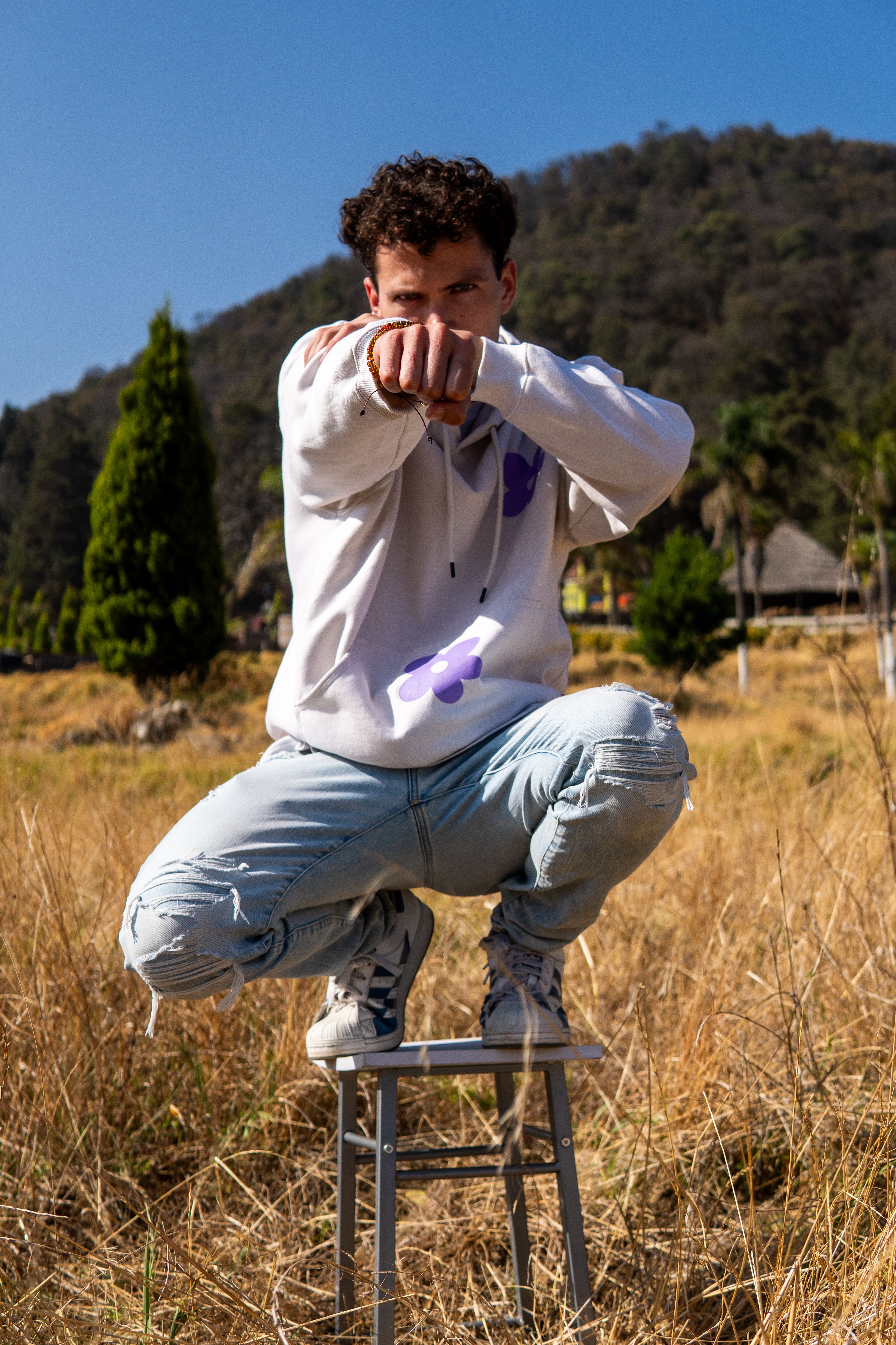 Man Squatting on Chair on Field and Posing · Free Stock Photo