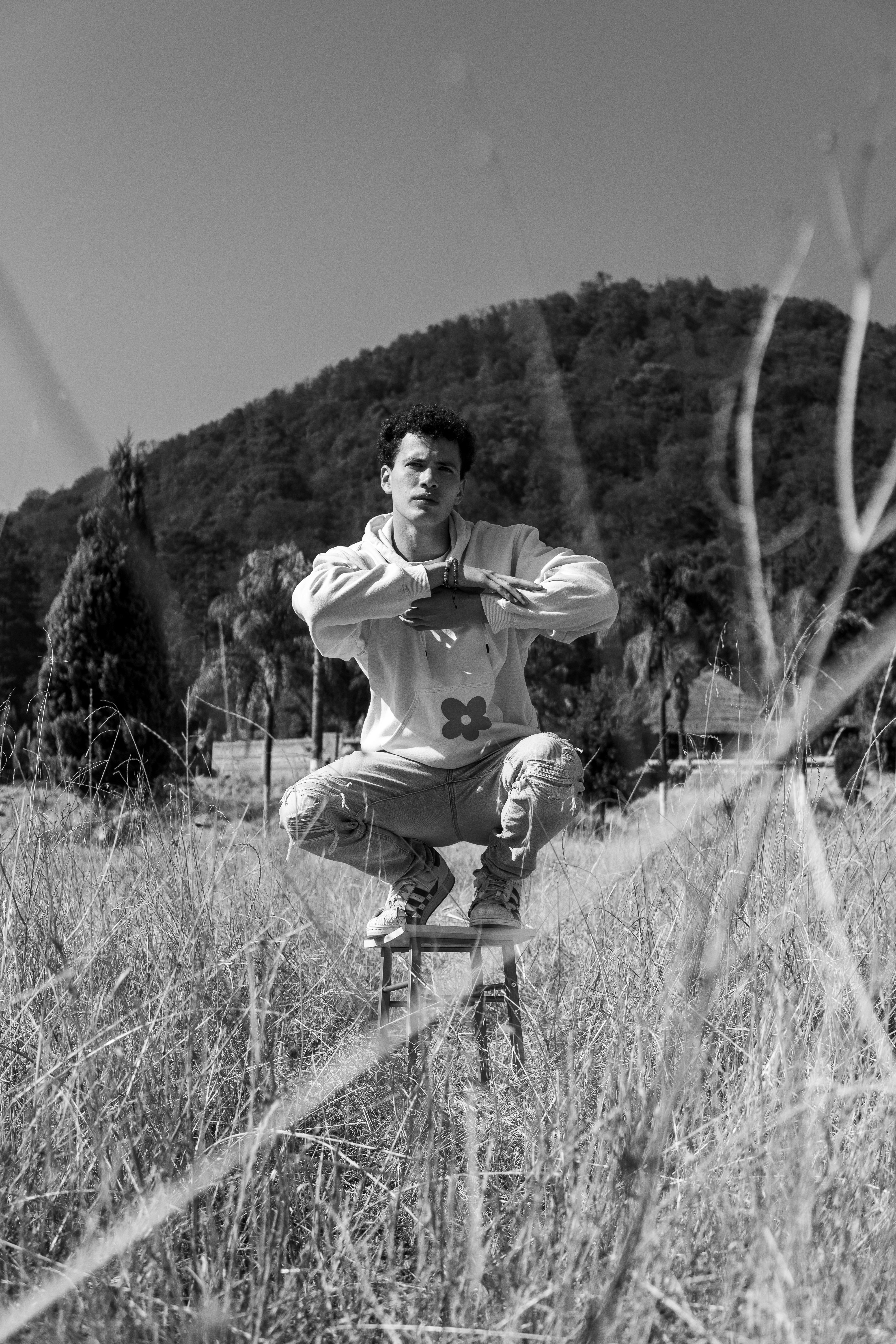 A Man Crouching on a Chair on a Field · Free Stock Photo