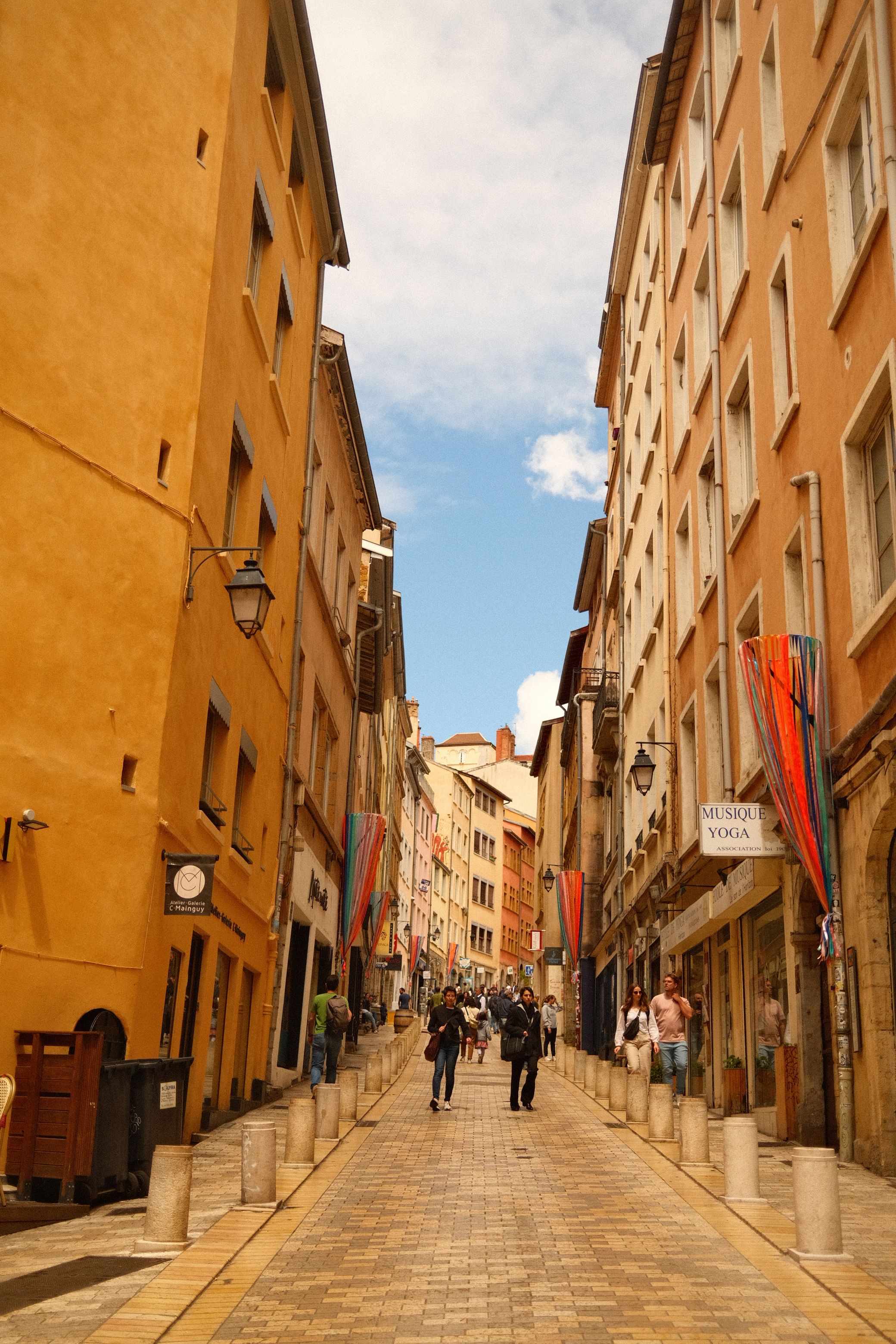 A narrow street with people walking down it · Free Stock Photo