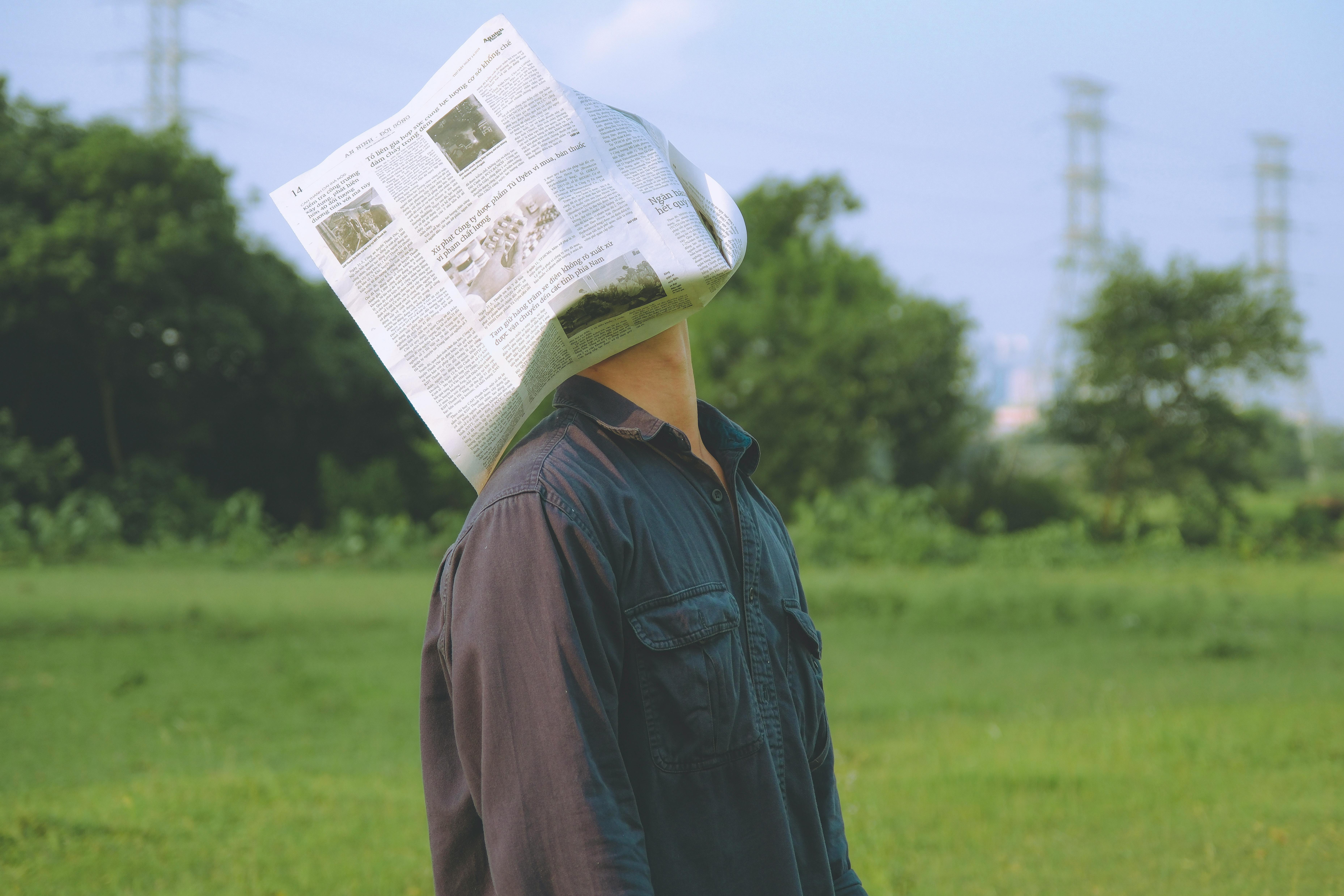 Man Standing with Newspaper on Head · Free Stock Photo