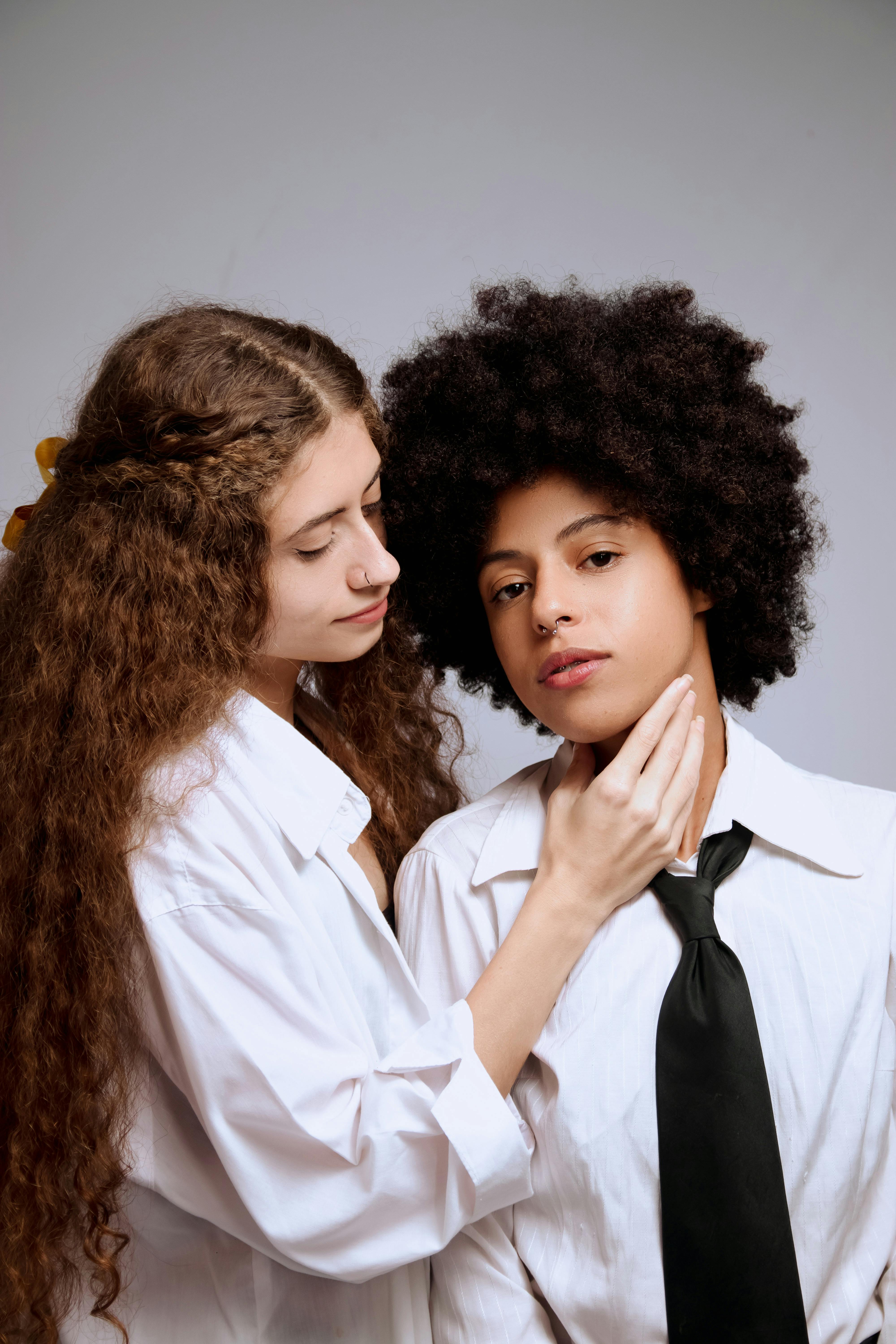 Two Young Affectionate Women against a White Background · Free Stock Photo