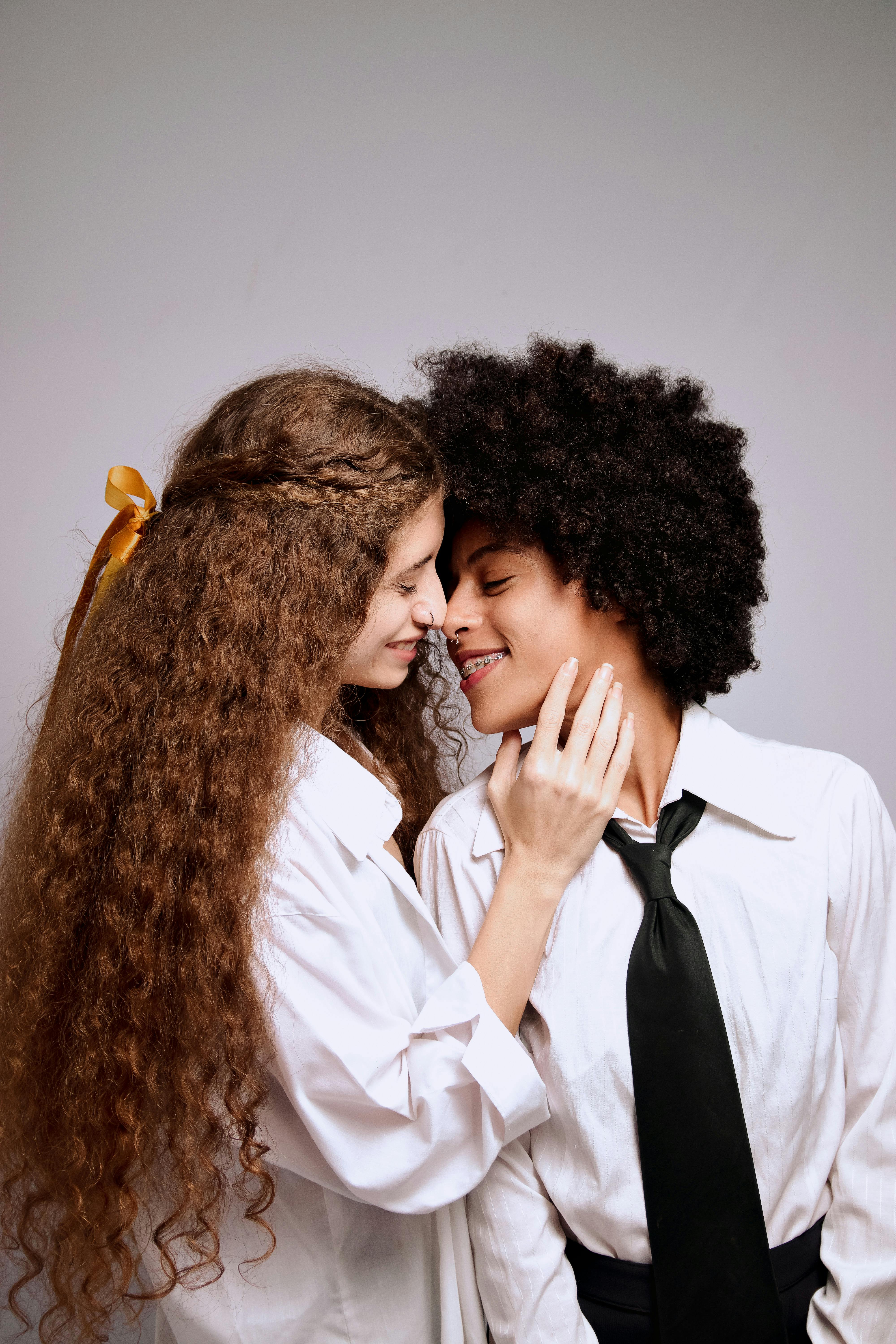 Two Young Affectionate Women against a White Background · Free Stock Photo