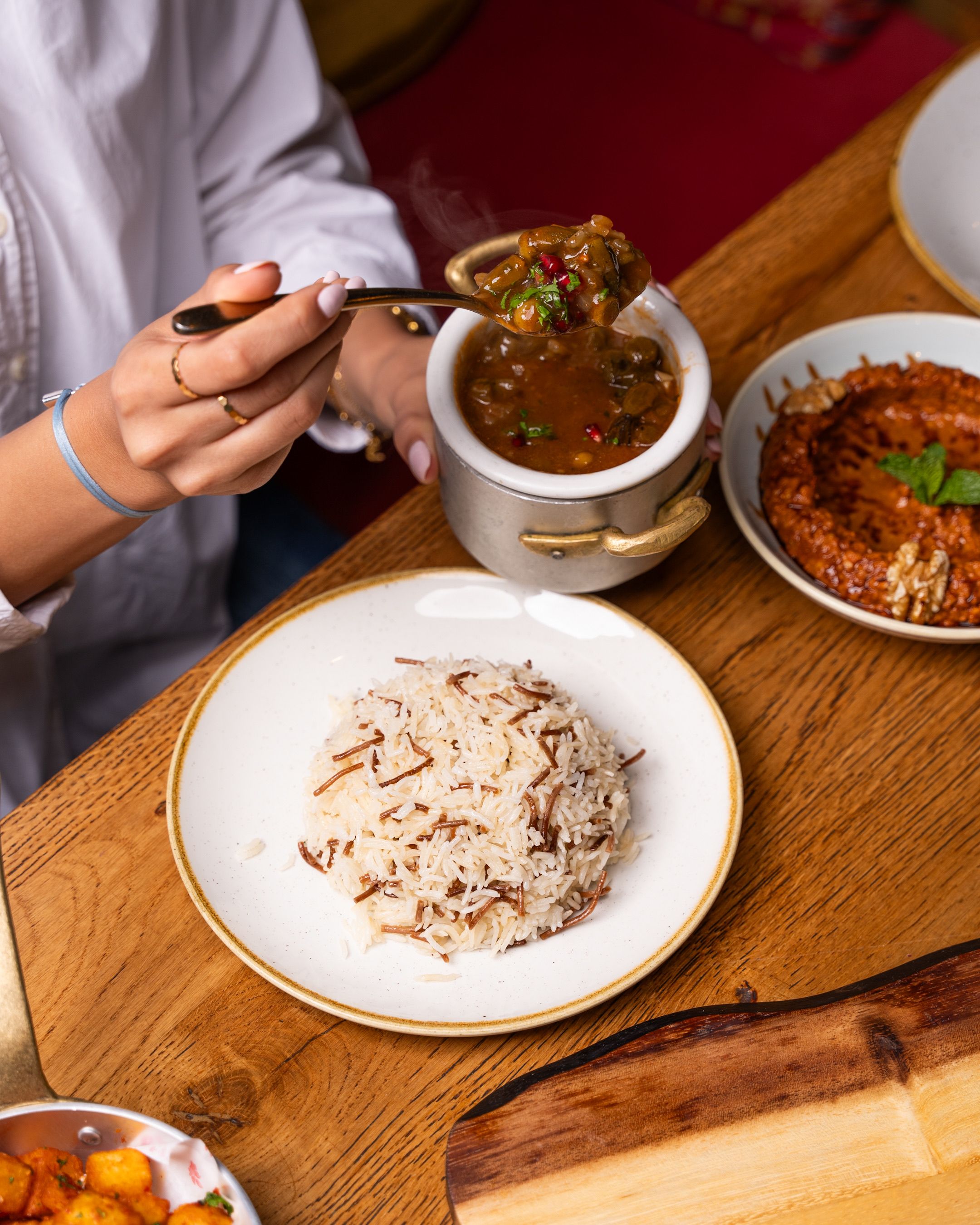 Woman Eating from Bowl on Pot on Table · Free Stock Photo