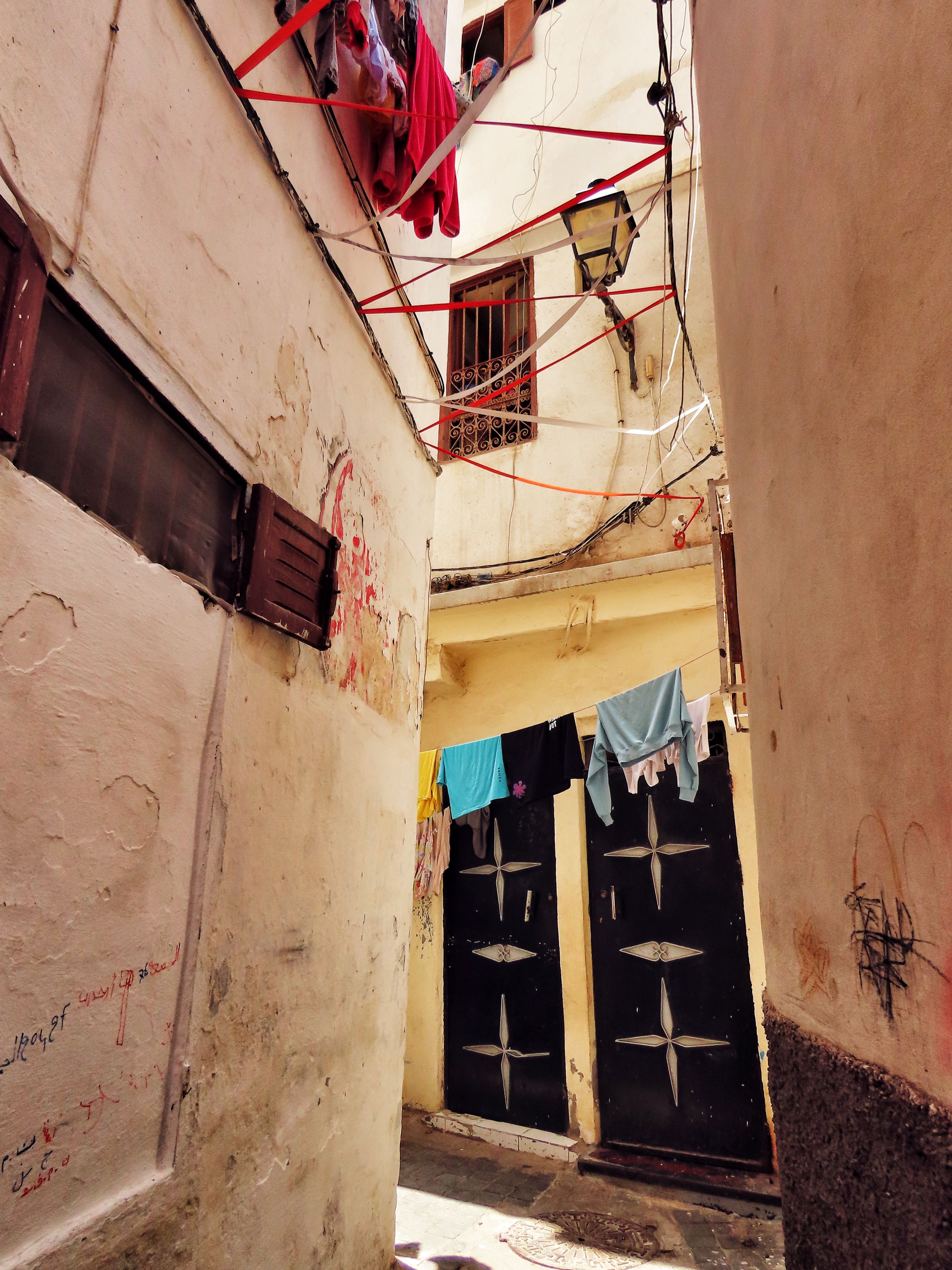 A narrow alley with clothes hanging on a line · Free Stock Photo