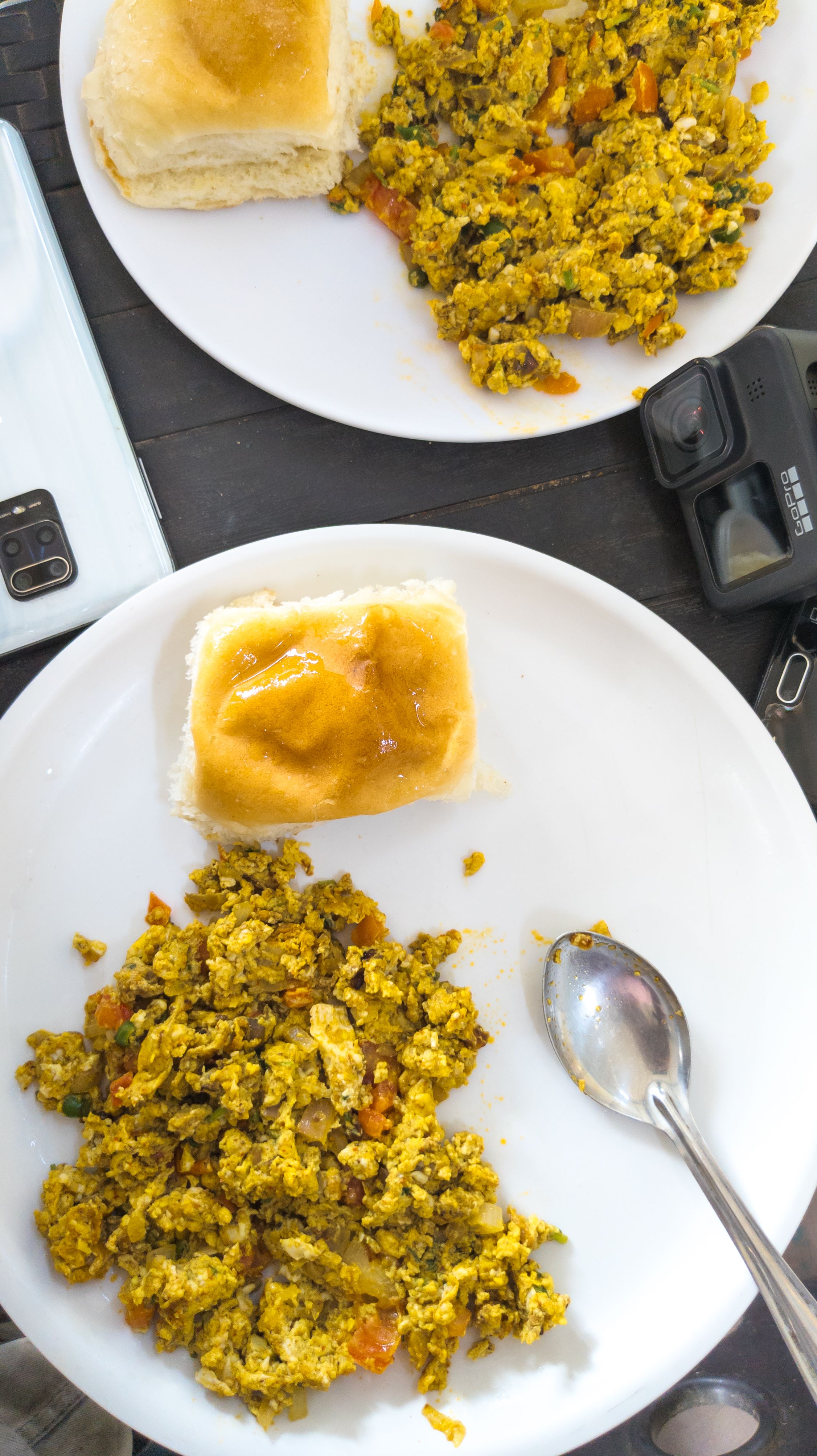 Two plates of food with a camera and a bread roll · Free Stock Photo