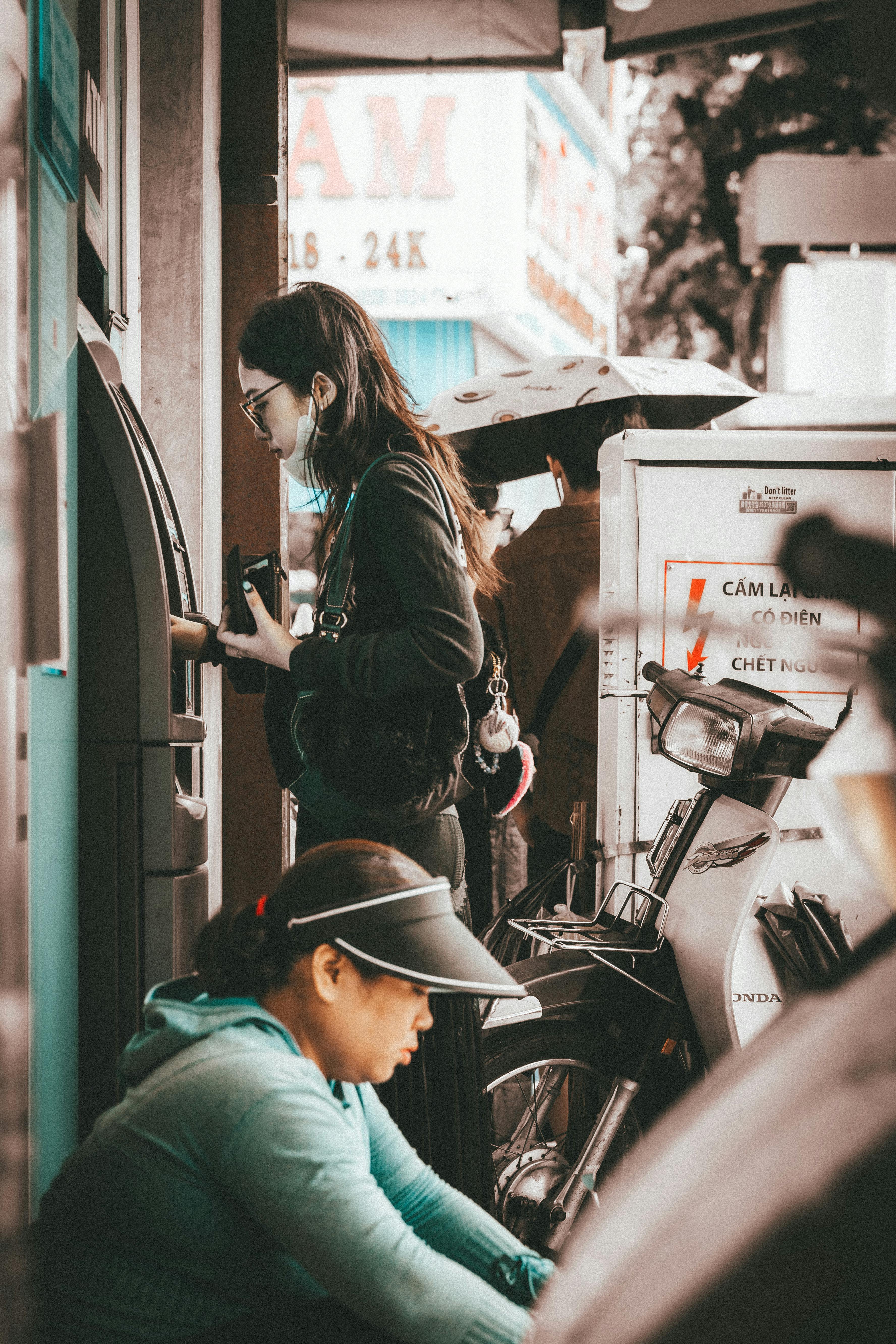 Side View of a Woman Using an ATM Machine · Free Stock Photo