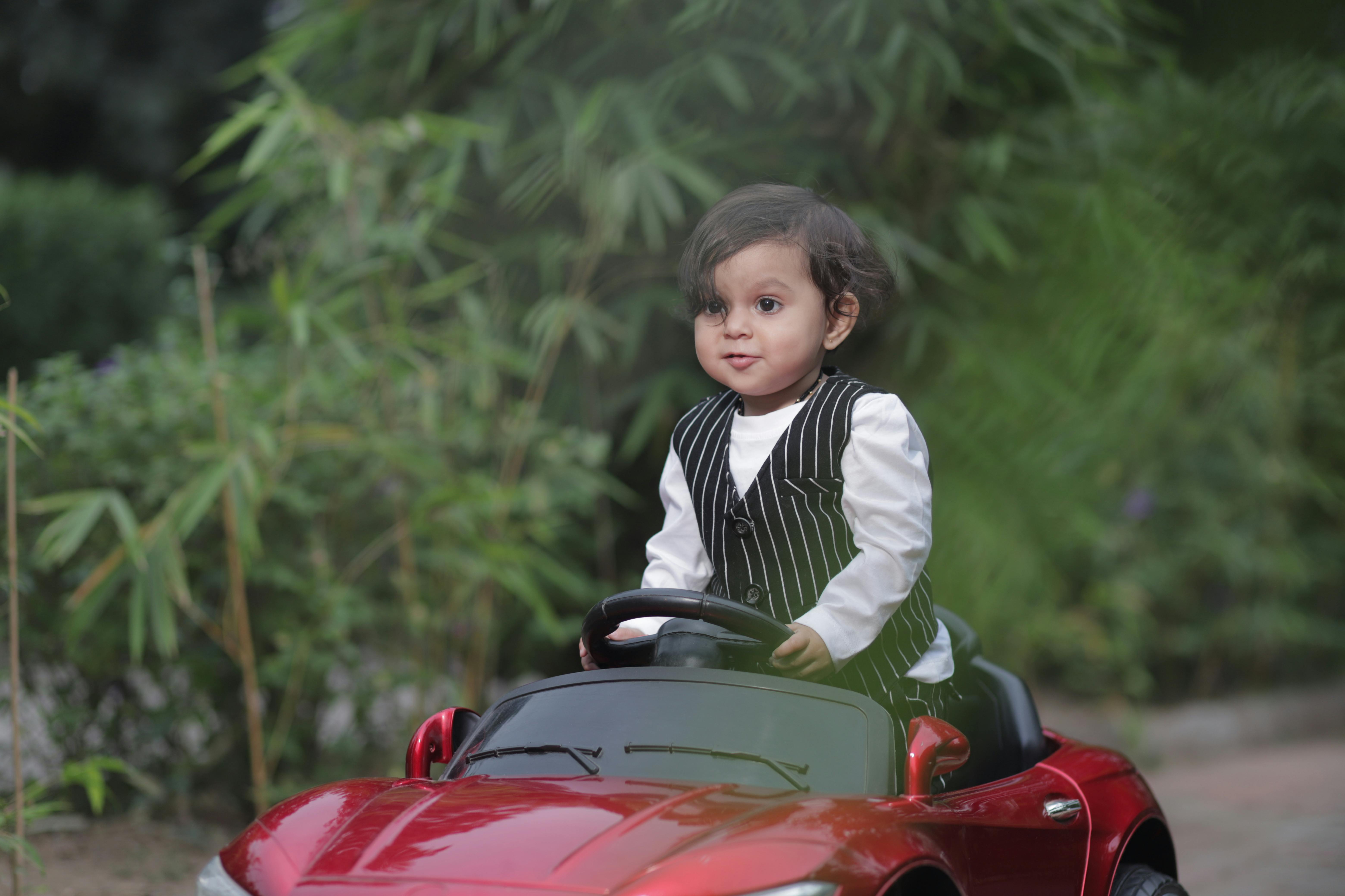 A Baby Riding in a Toy Car · Free Stock Photo