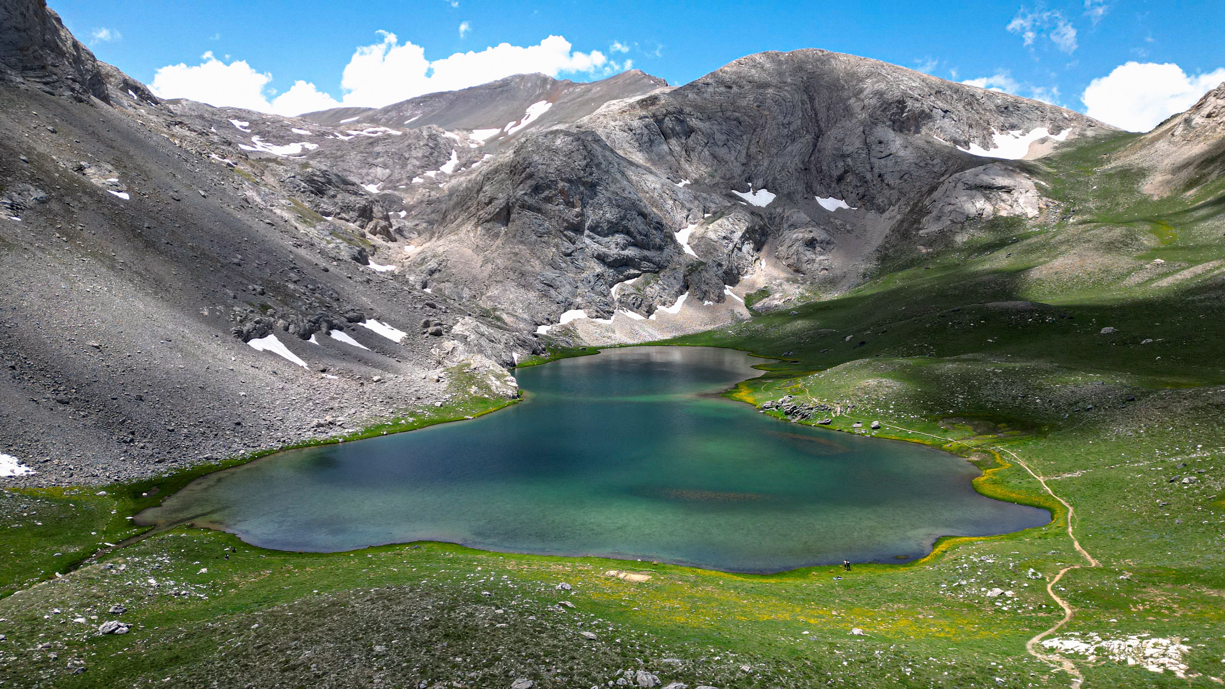 Lake Among Gray Barren Mountains and Green Pastures · Free Stock Photo