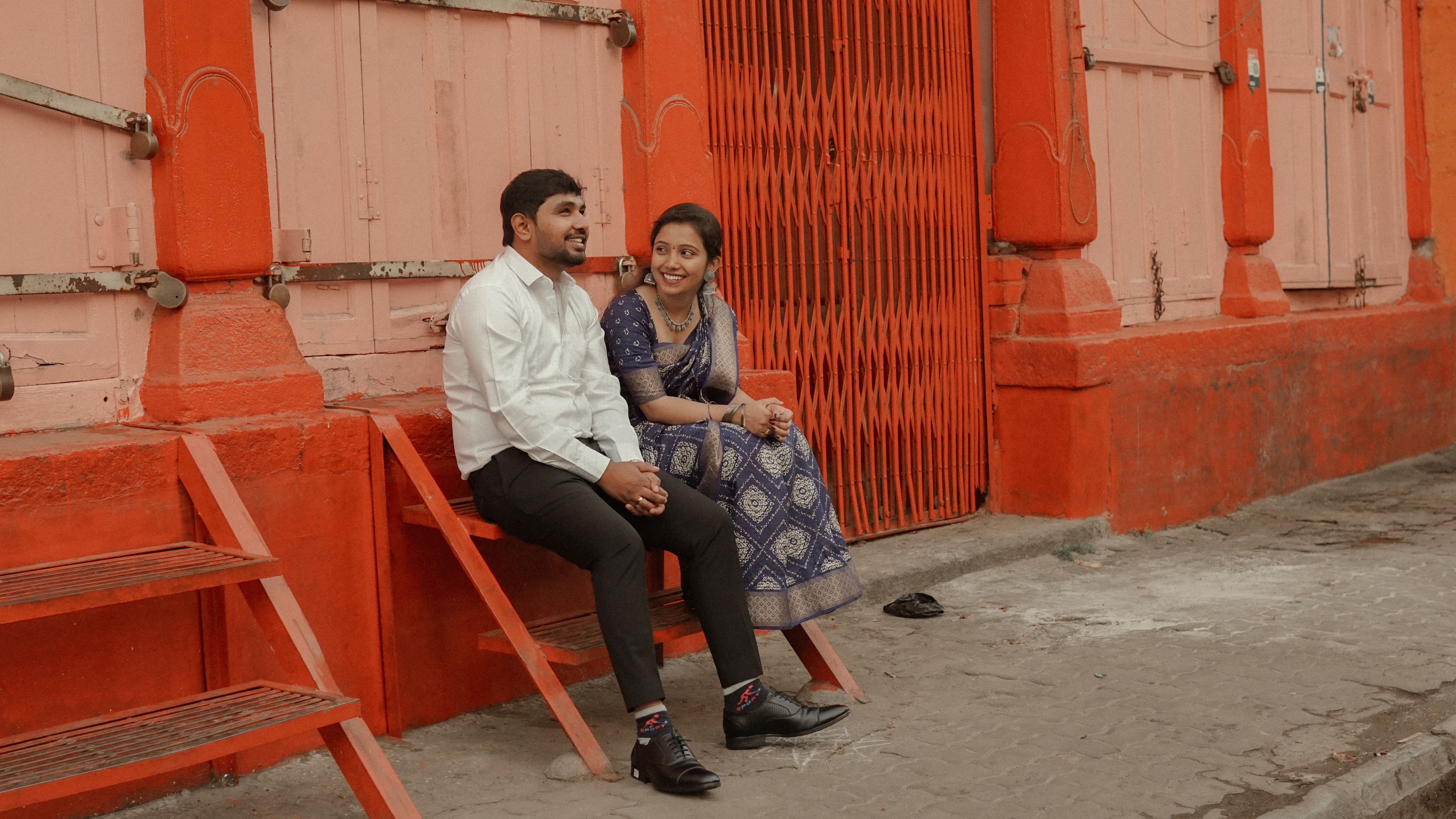 Young Couple Sitting Together on the Steps and Smiling · Free Stock Photo