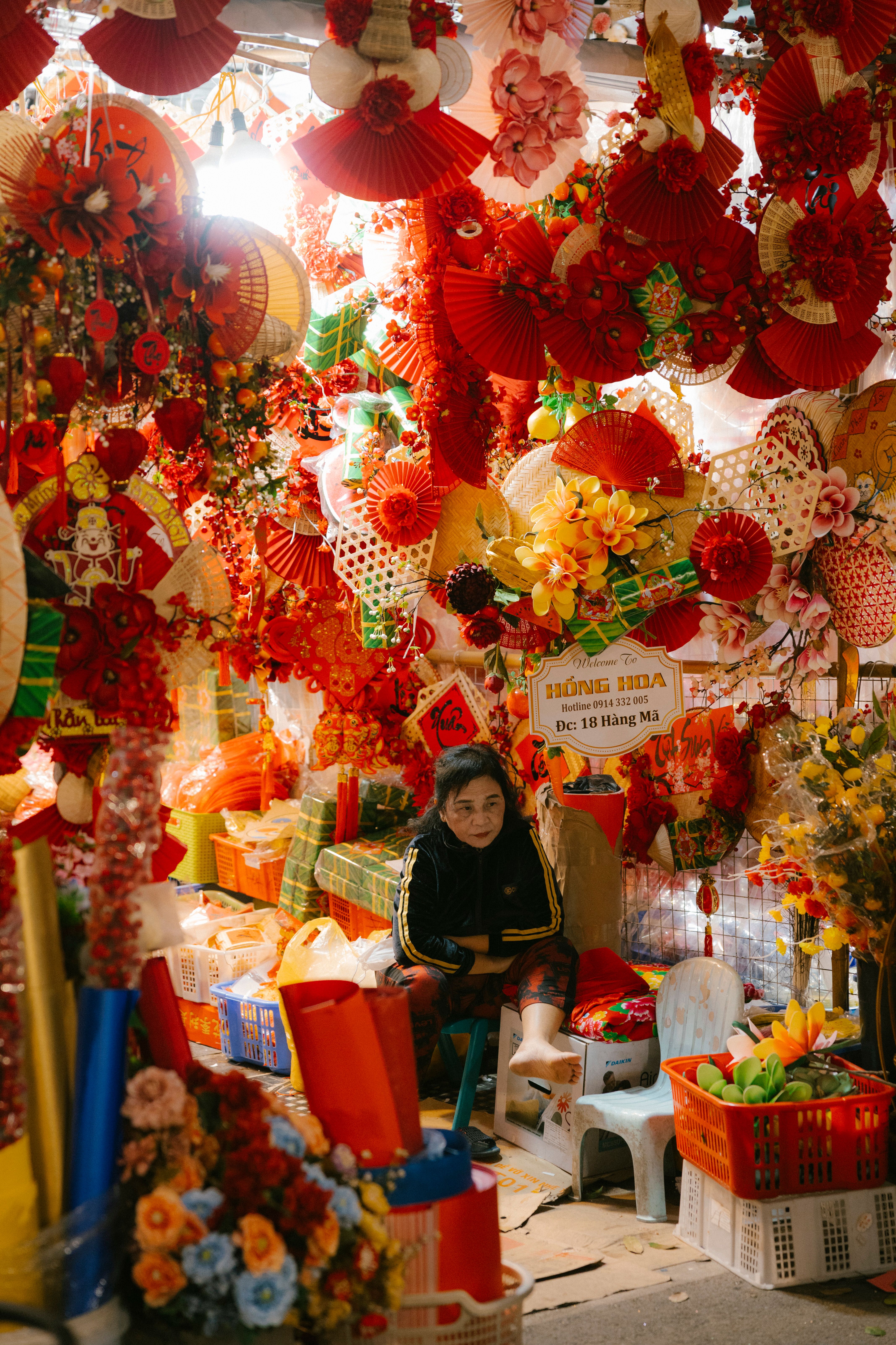 Merchant at Market Stall with Flowers and Decor · Free Stock Photo