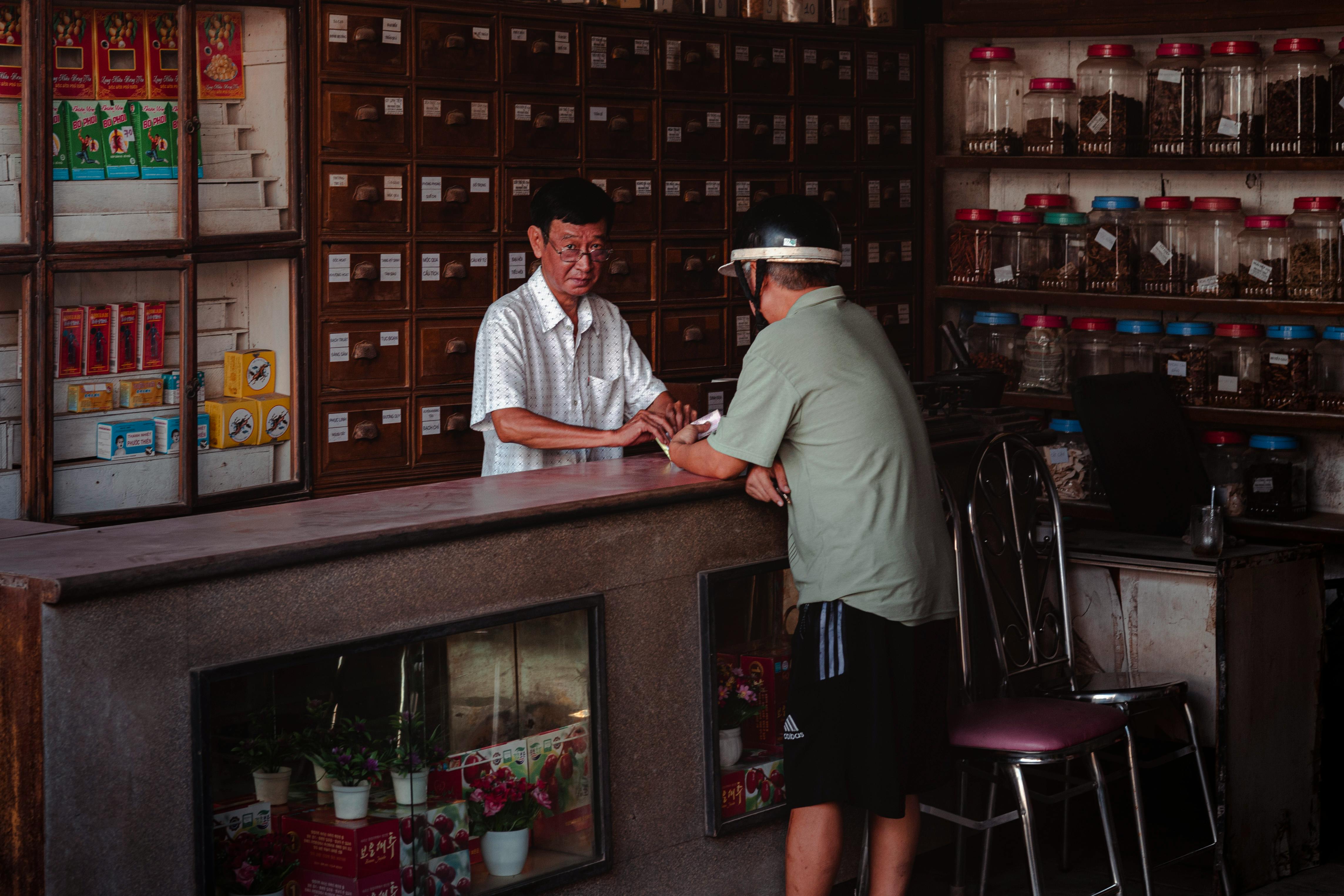 Store Owner Talking with Customer in Asia · Free Stock Photo