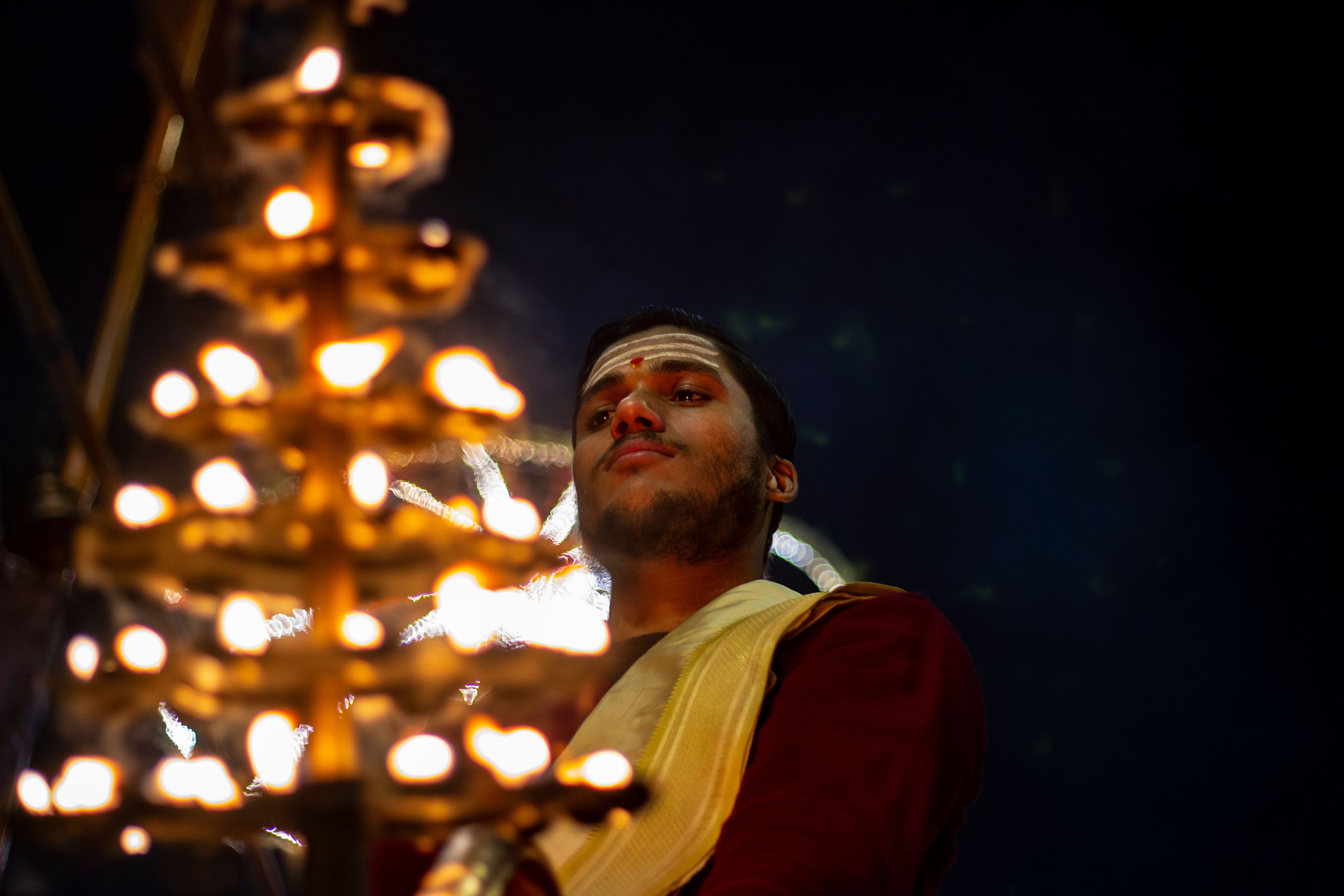 A Man Standing on the Background of Burning Candles at a Ceremony ...