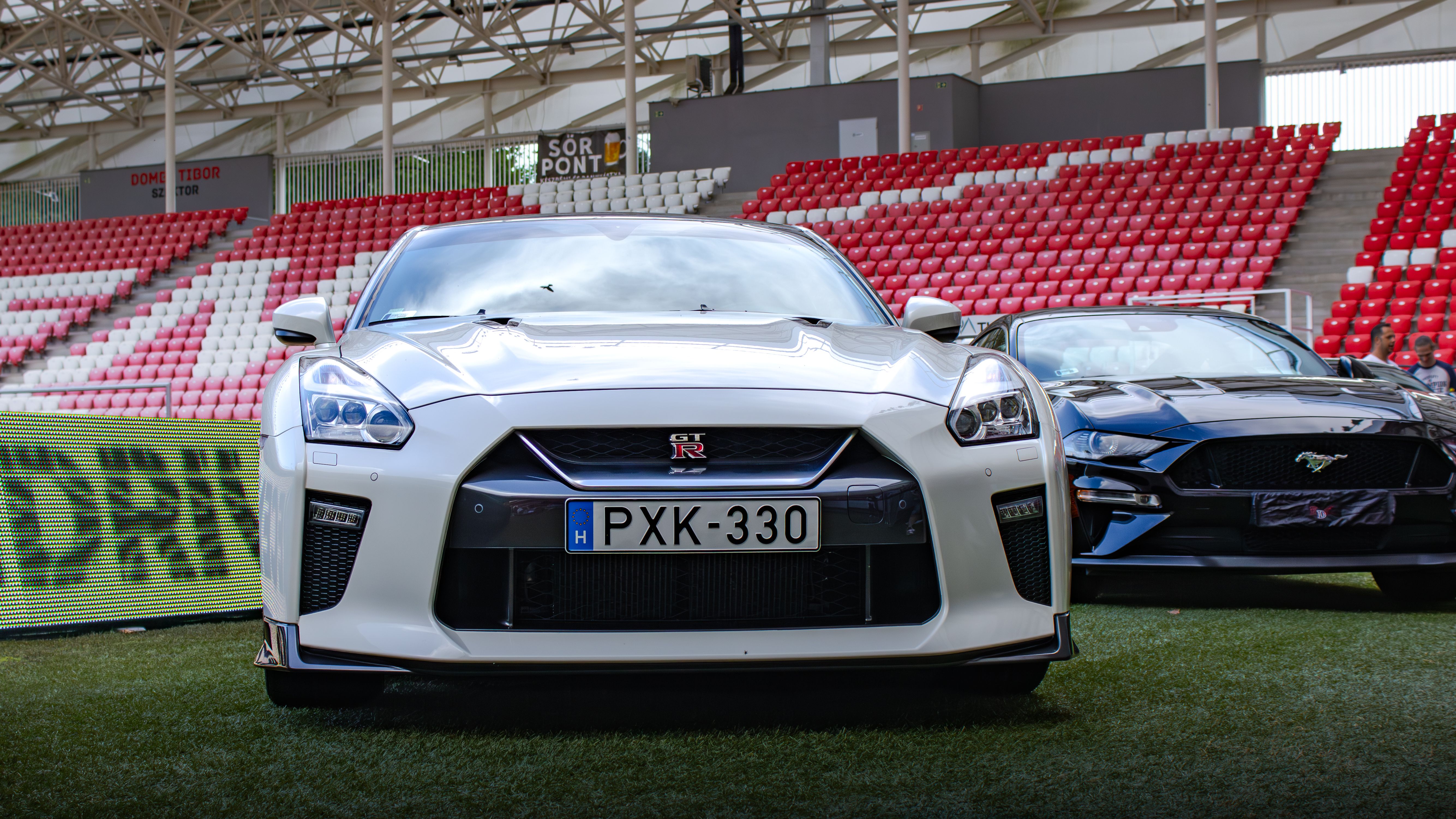 Two cars parked in front of a stadium · Free Stock Photo