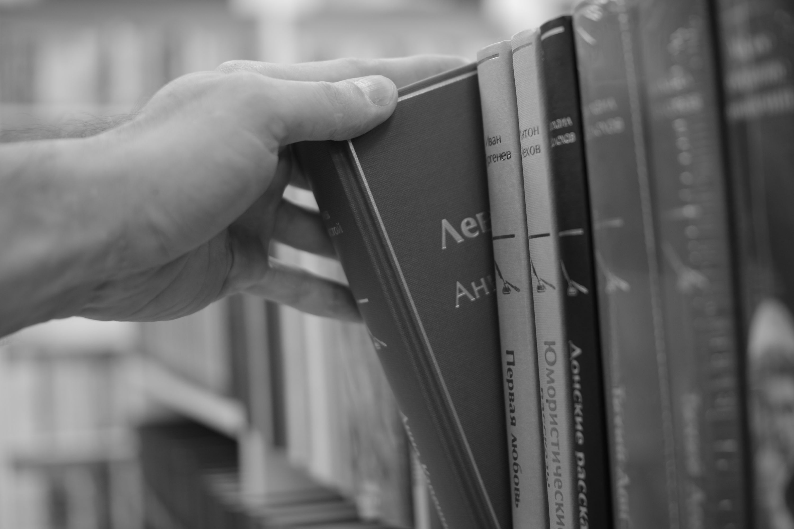 Man Hand over Books in Black and White · Free Stock Photo