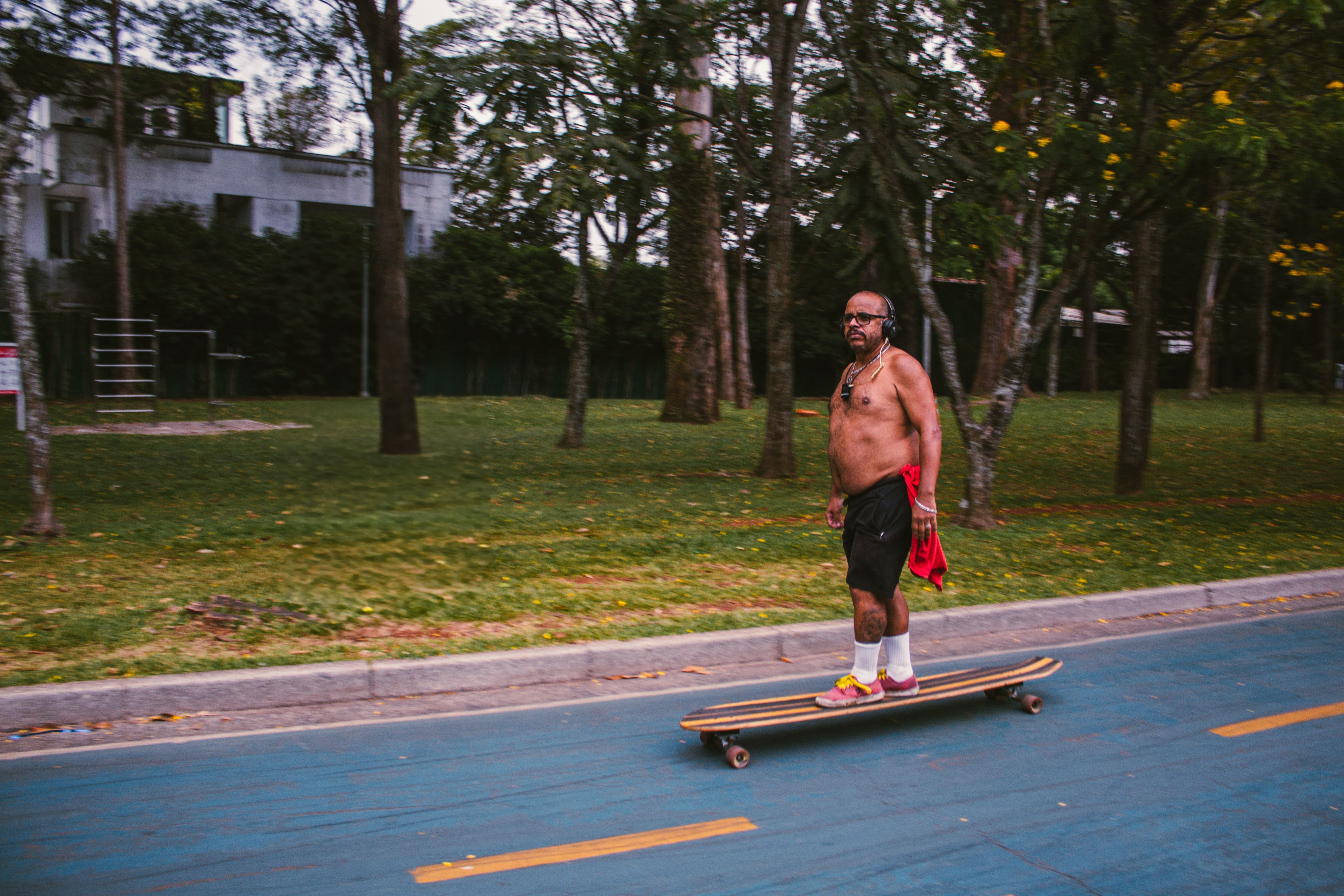 Shirtless Man Skateboarding along a Street · Free Stock Photo