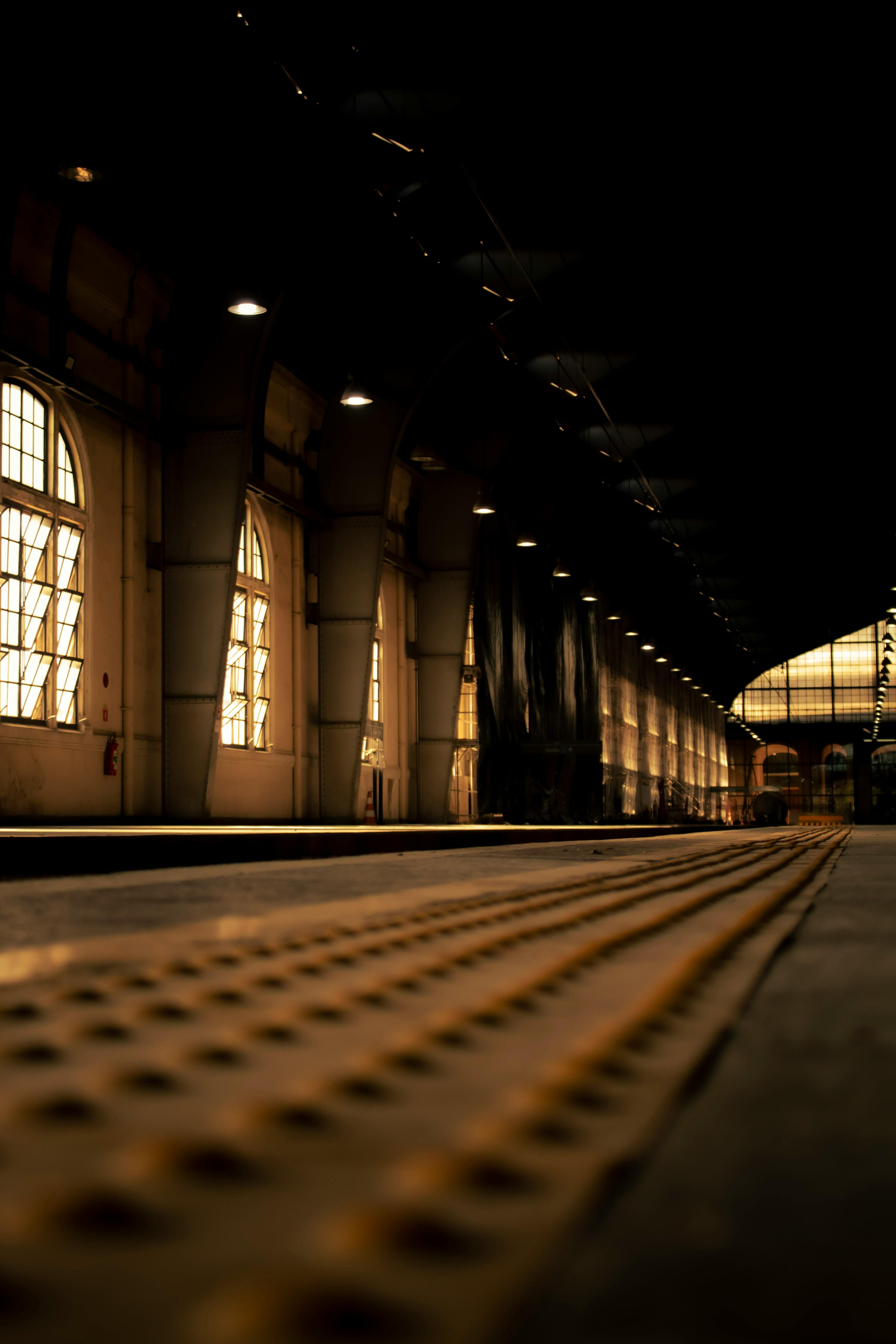 A train station with a train in the distance · Free Stock Photo
