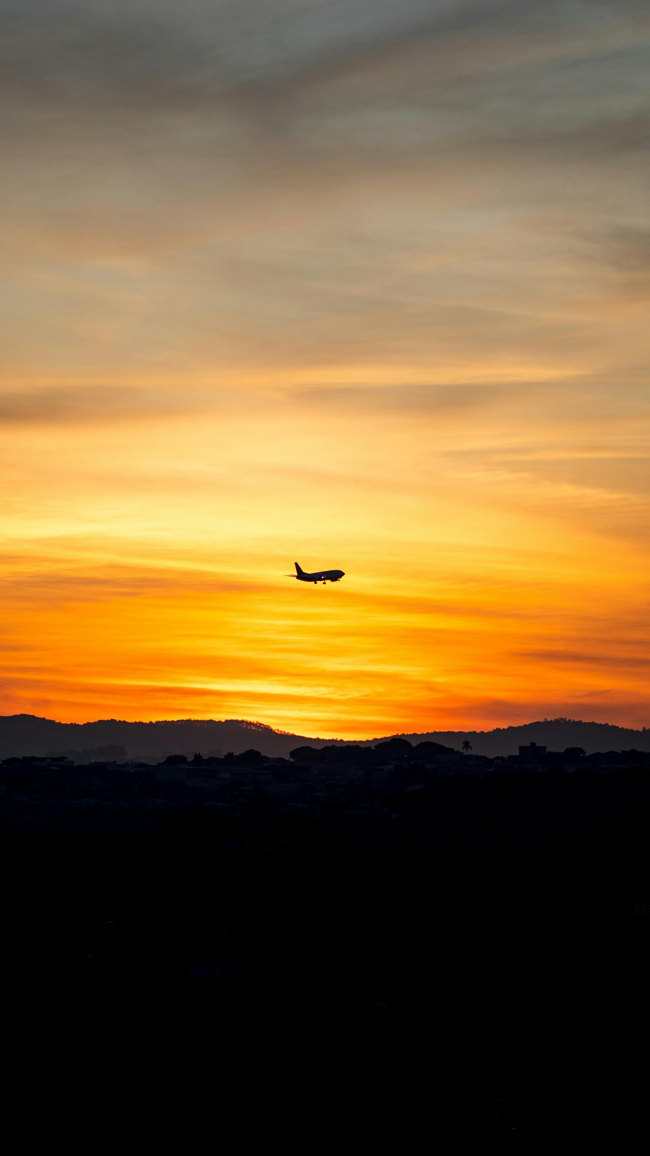 Silhouette of a Plane Flying Over Sunset Sky · Free Stock Photo
