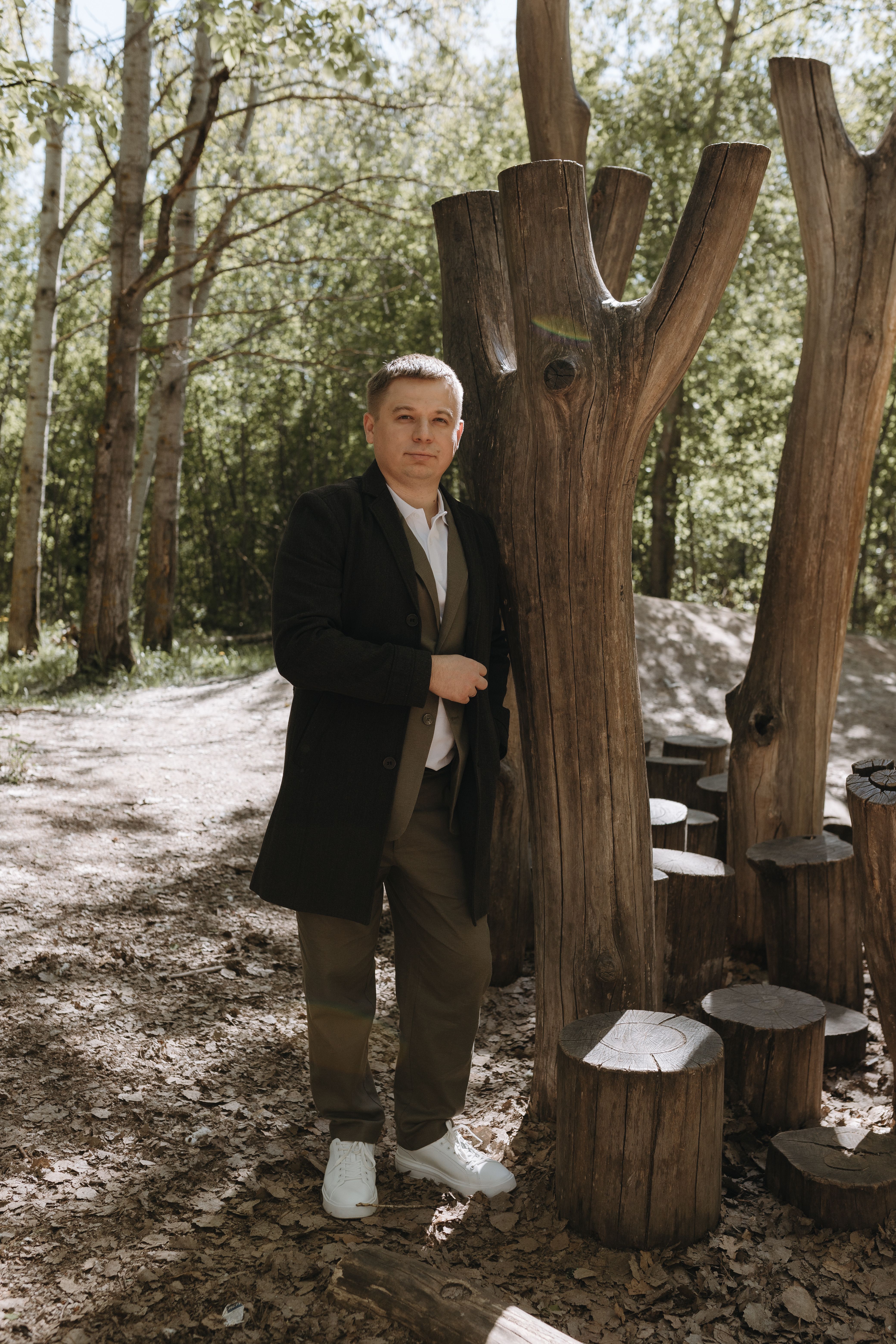 A man standing next to a tree stump · Free Stock Photo