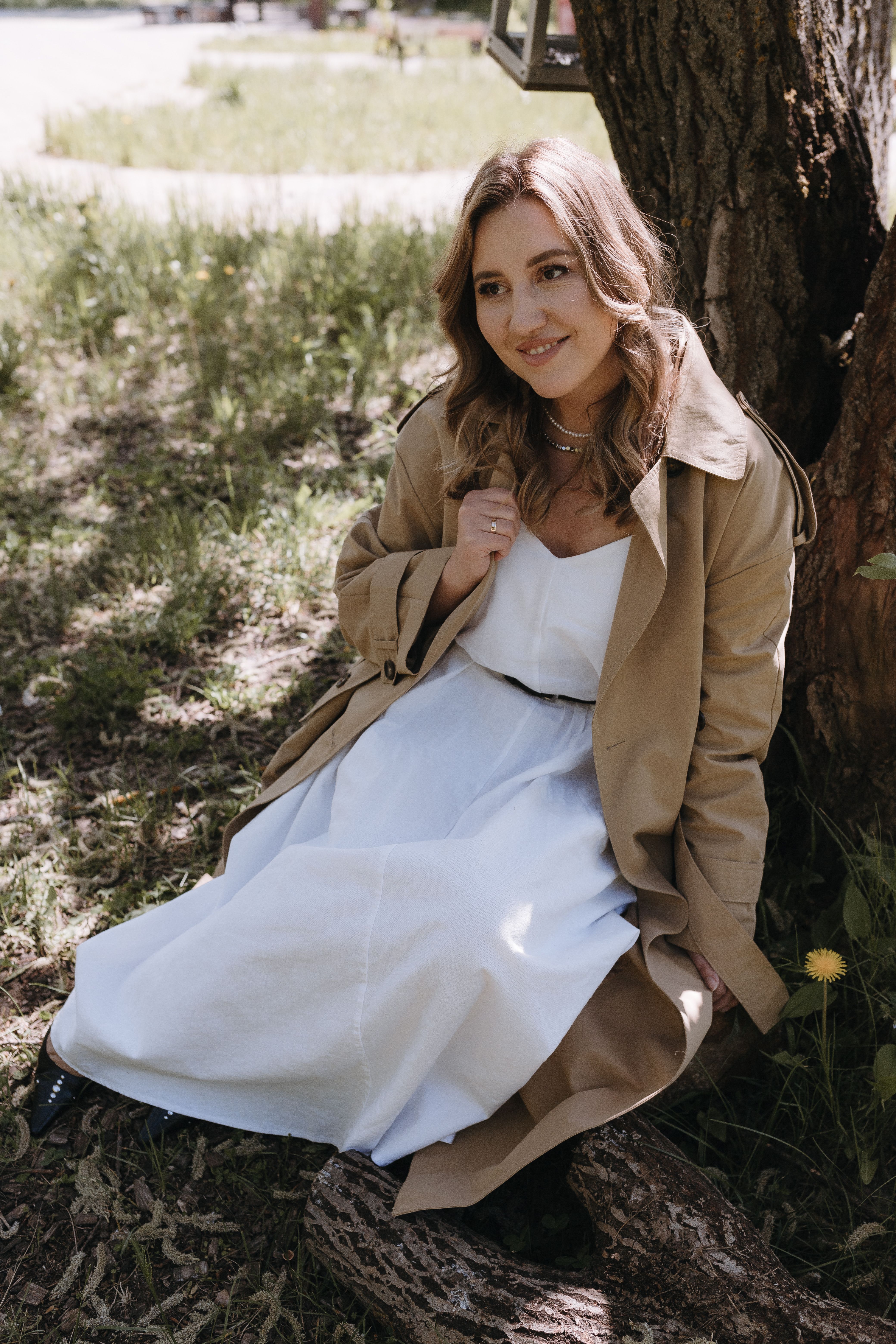 An Elegant Woman Wearing a Trench Sitting in the Park · Free Stock Photo
