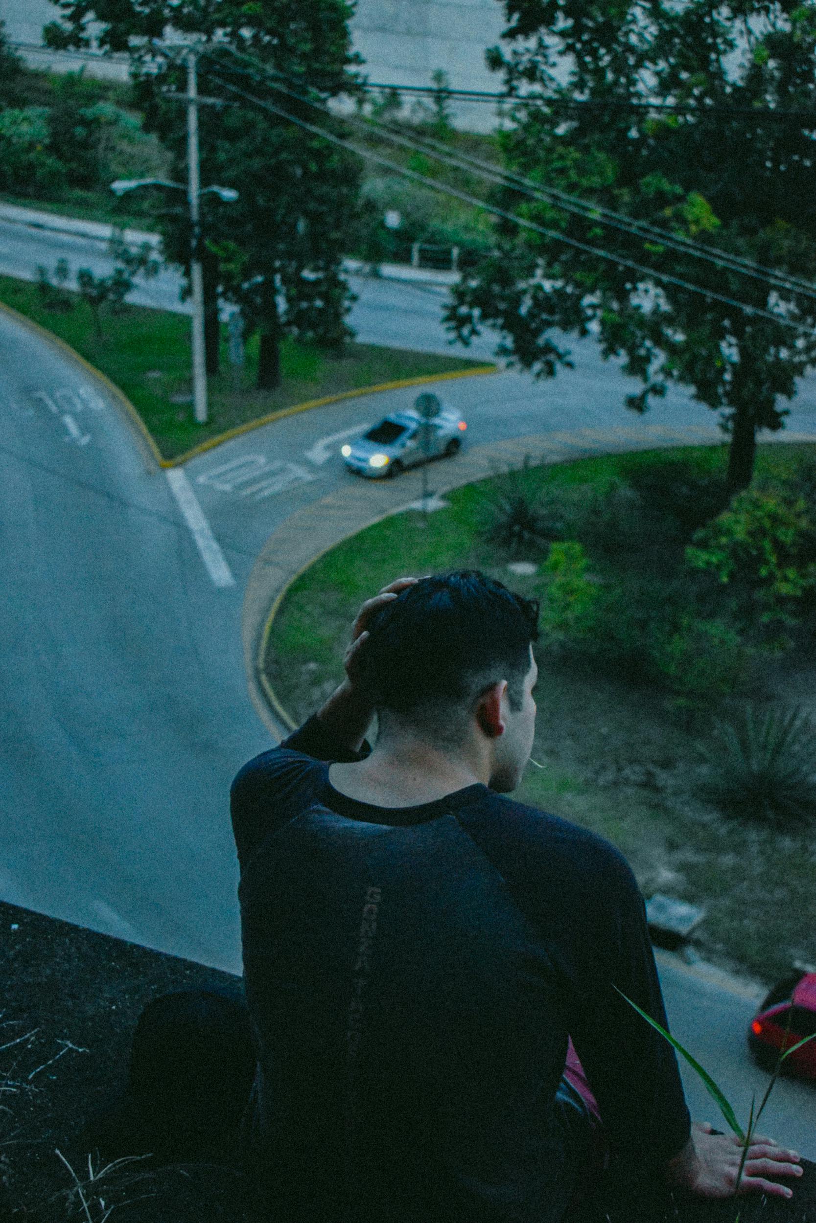 Back View of Brunette Man with Short Hair on Balcony Overlooking Street ...