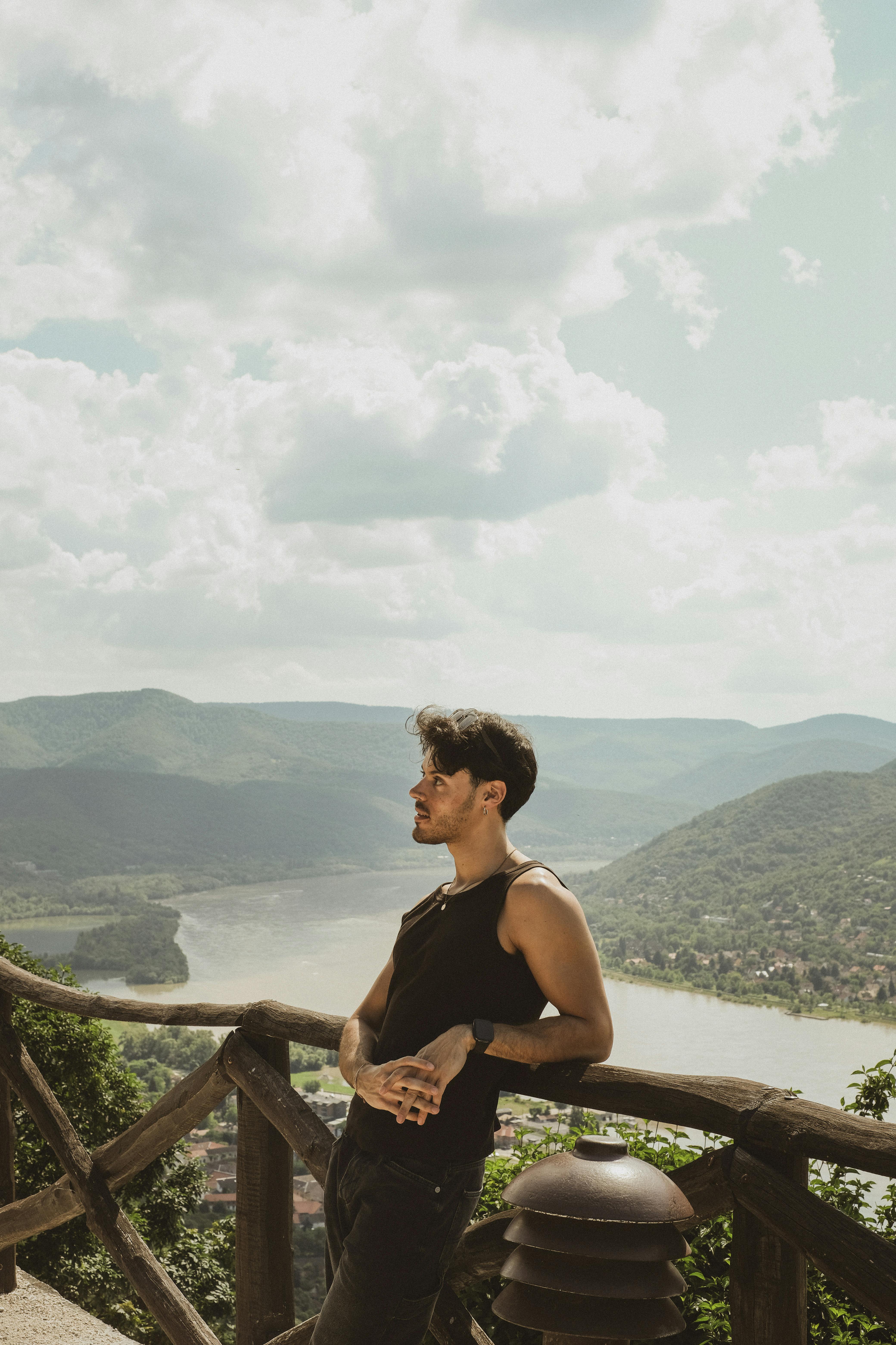 Man Leaning on Railing against Valley with River · Free Stock Photo