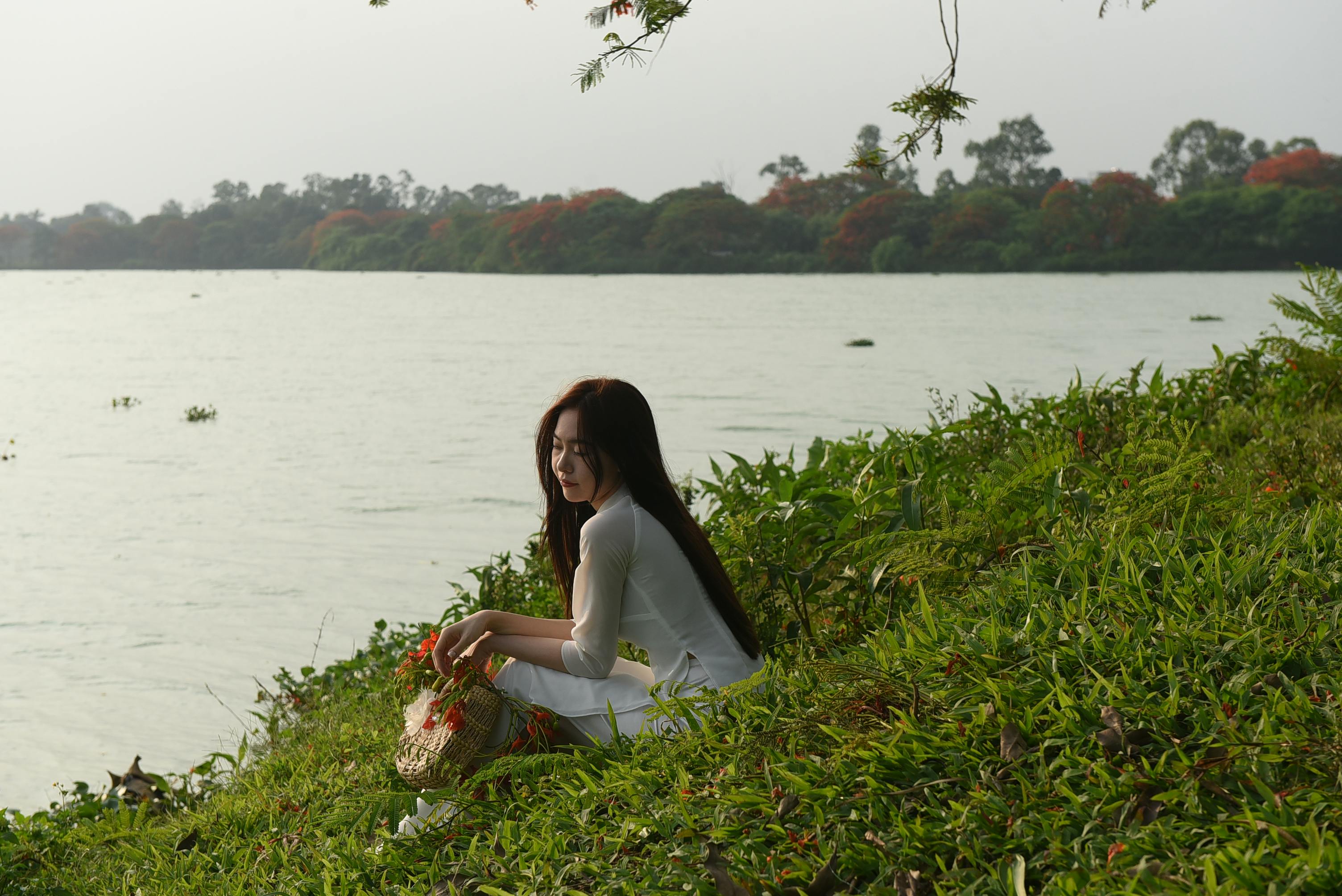 Woman in Dress and with Bag of Flowers Sitting on Riverbank · Free ...