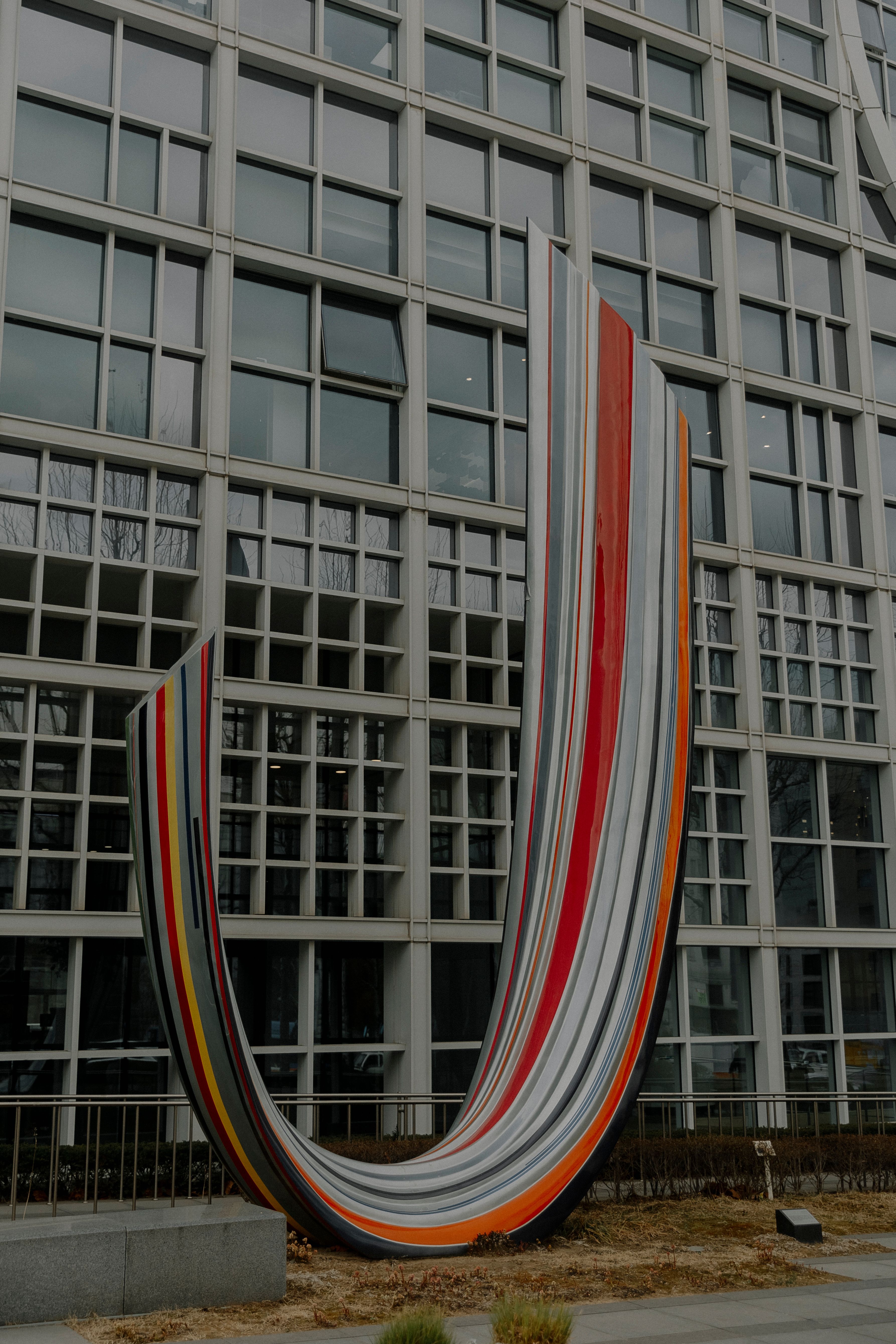 A sculpture of a rainbow colored ribbon in front of a building · Free ...