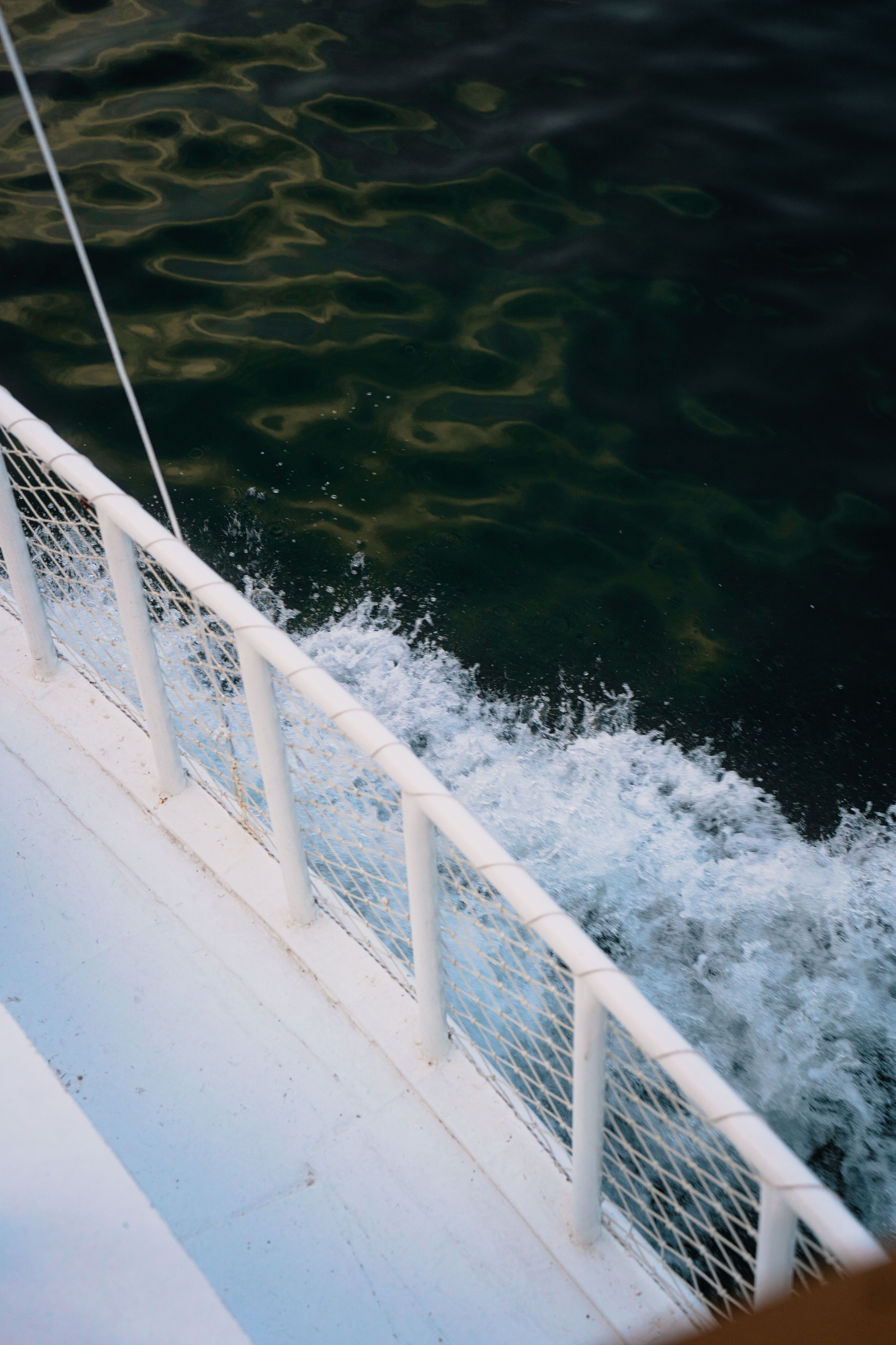 A white boat with a railing and water · Free Stock Photo