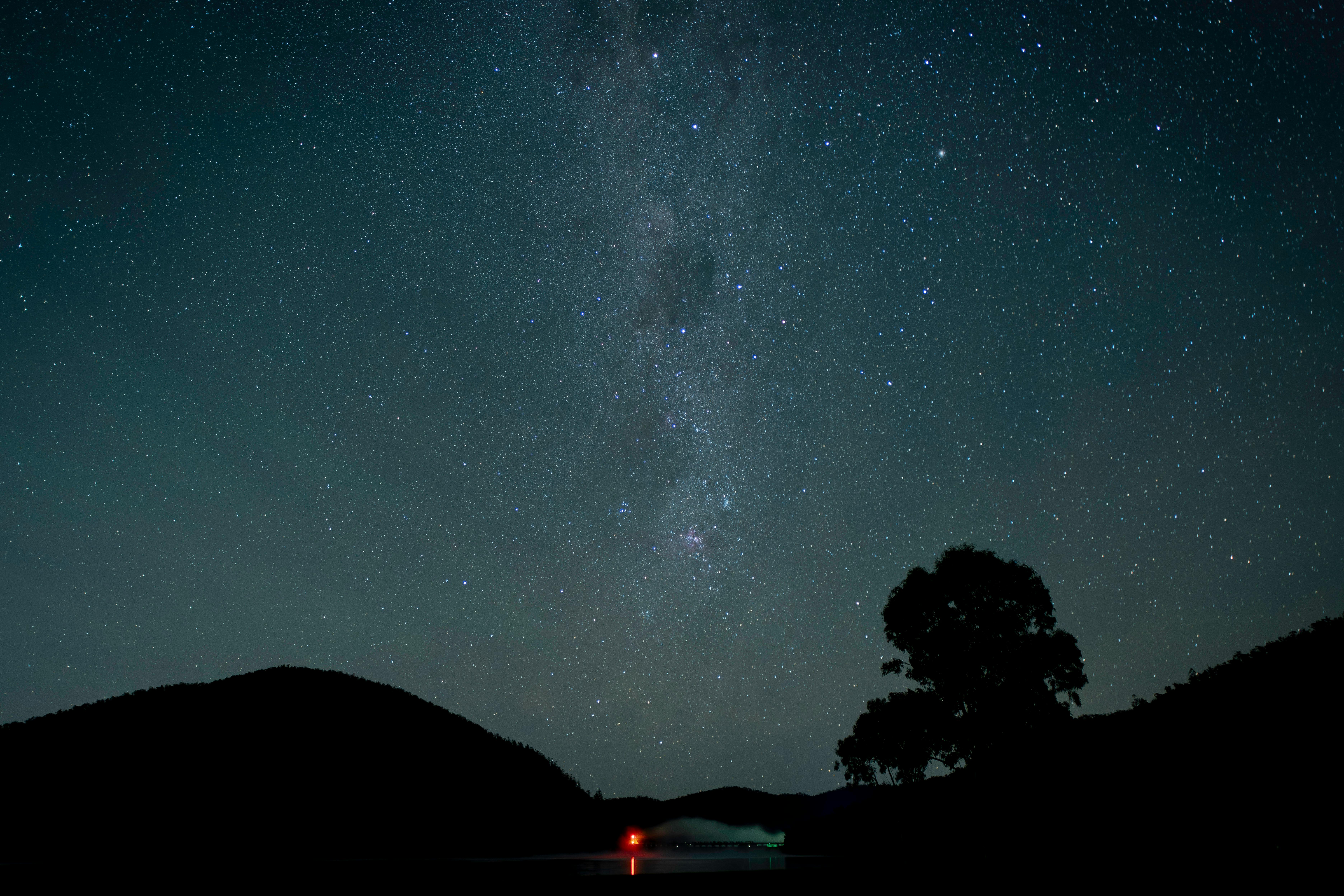 A boat is under the stars in the night sky · Free Stock Photo
