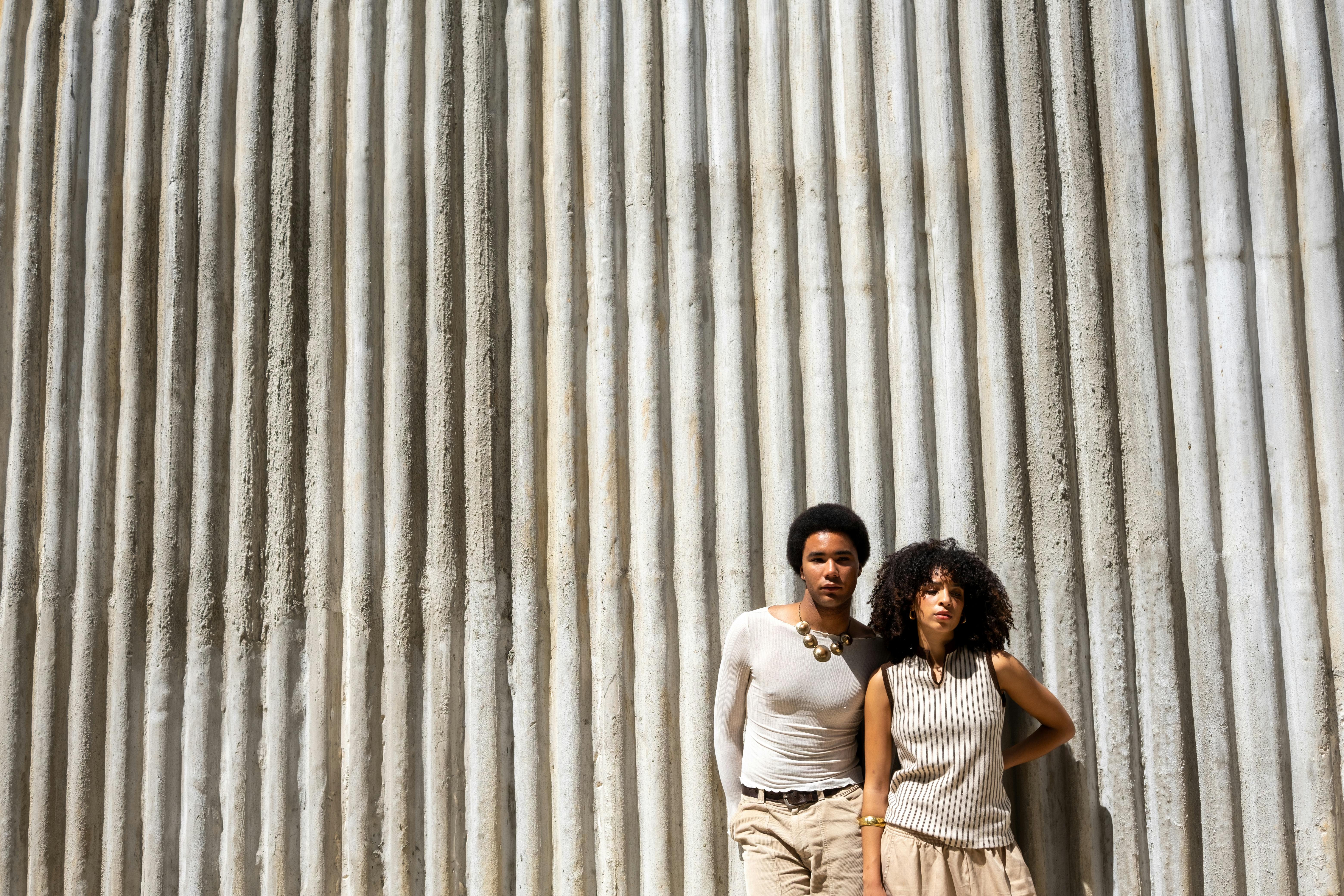 Two People Standing by a Wall · Free Stock Photo