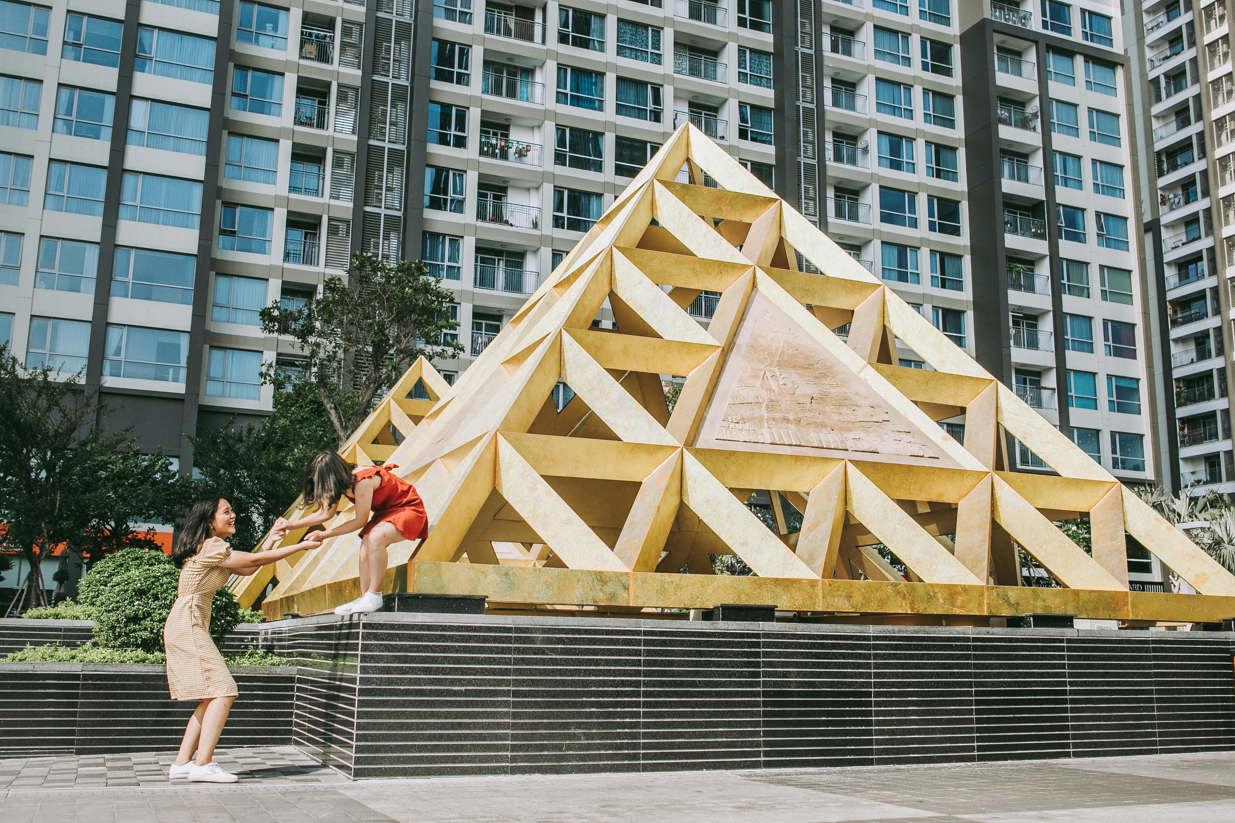 Women Playing on Triangular Structure · Free Stock Photo