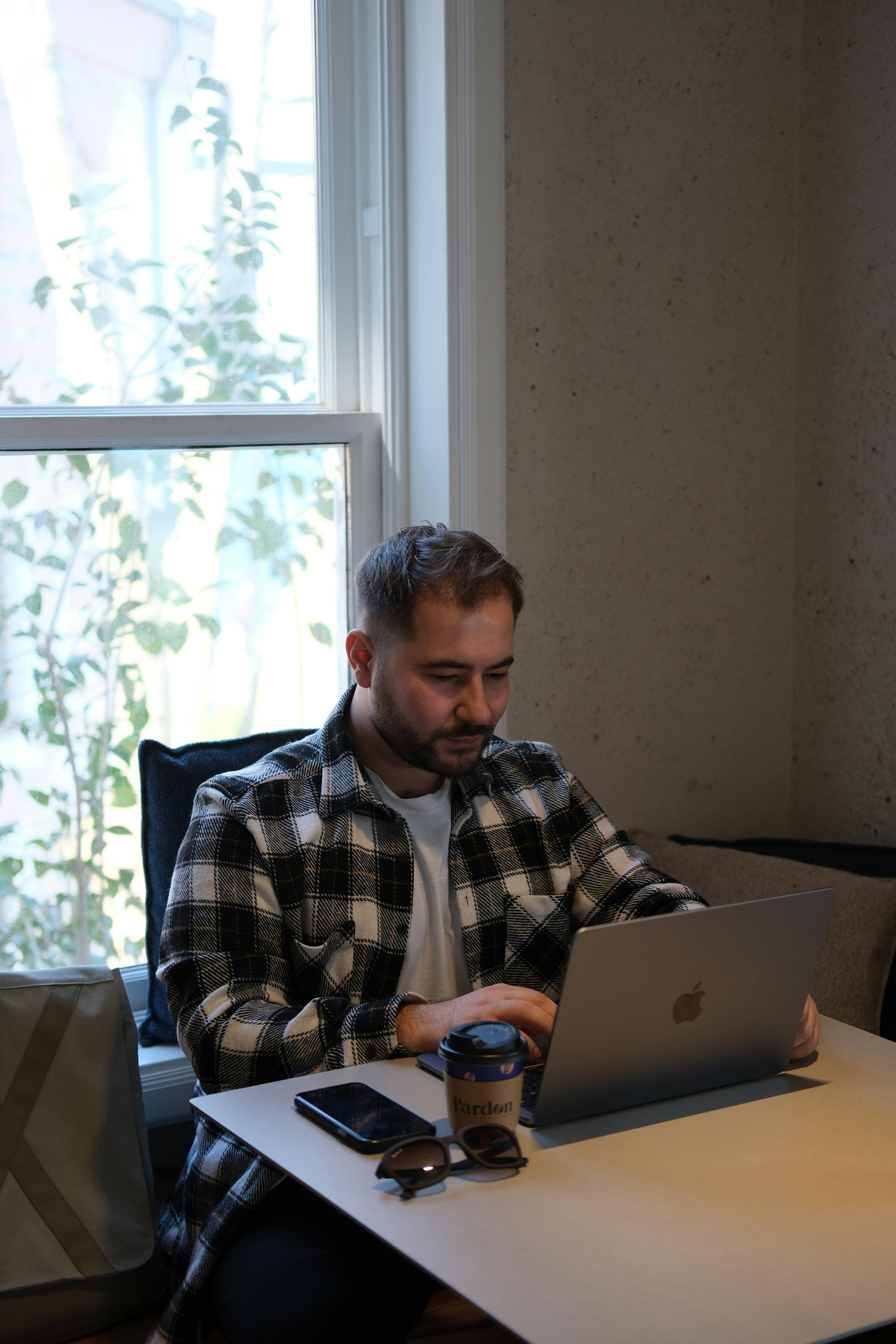 A Man Sitting at the Desk with a Laptop · Free Stock Photo