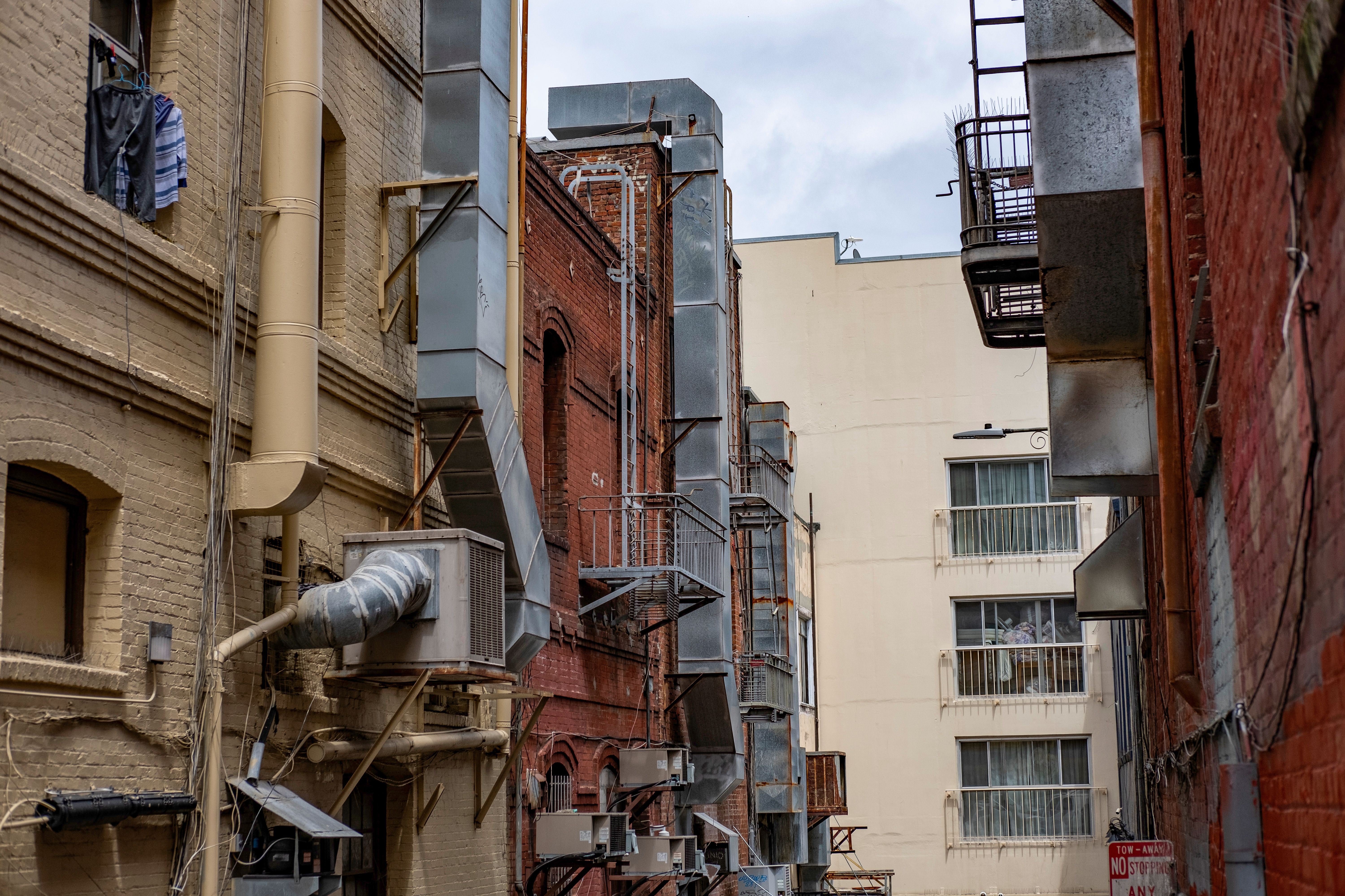 A narrow alley with buildings and a fire escape · Free Stock Photo