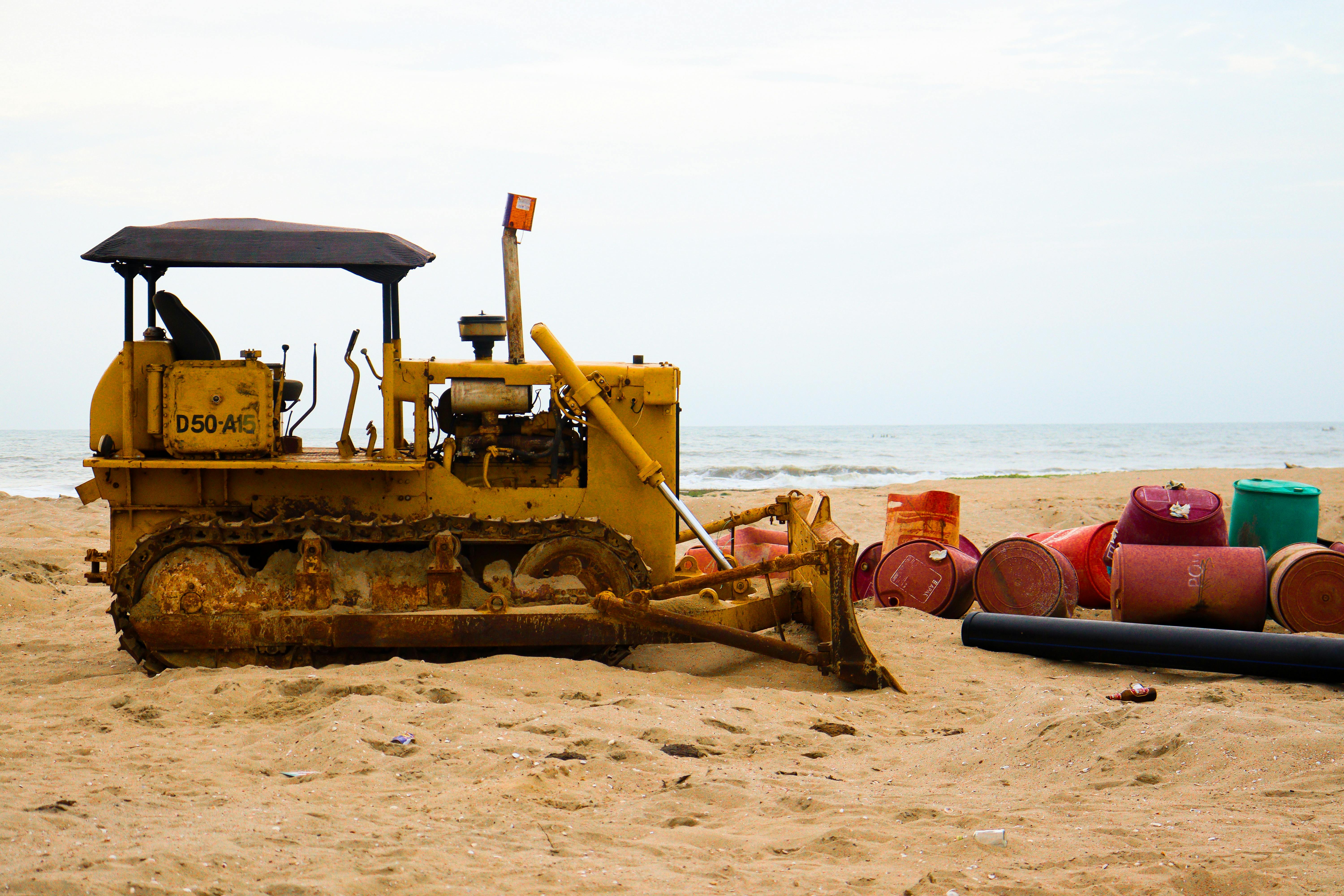 Bulldozer and Kegs on Beach · Free Stock Photo