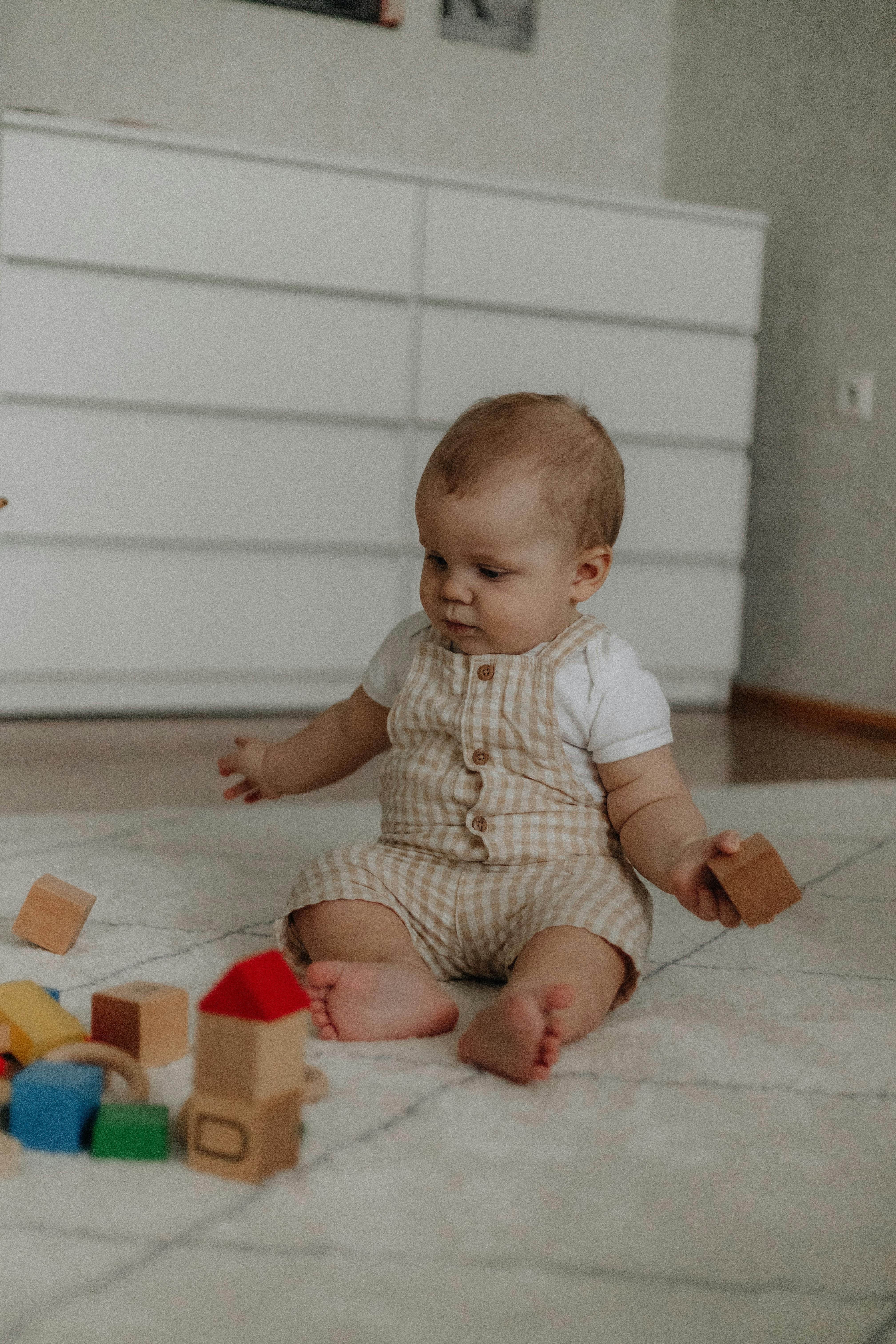 Baby Sitting on Carpet and Playing with Blocks · Free Stock Photo