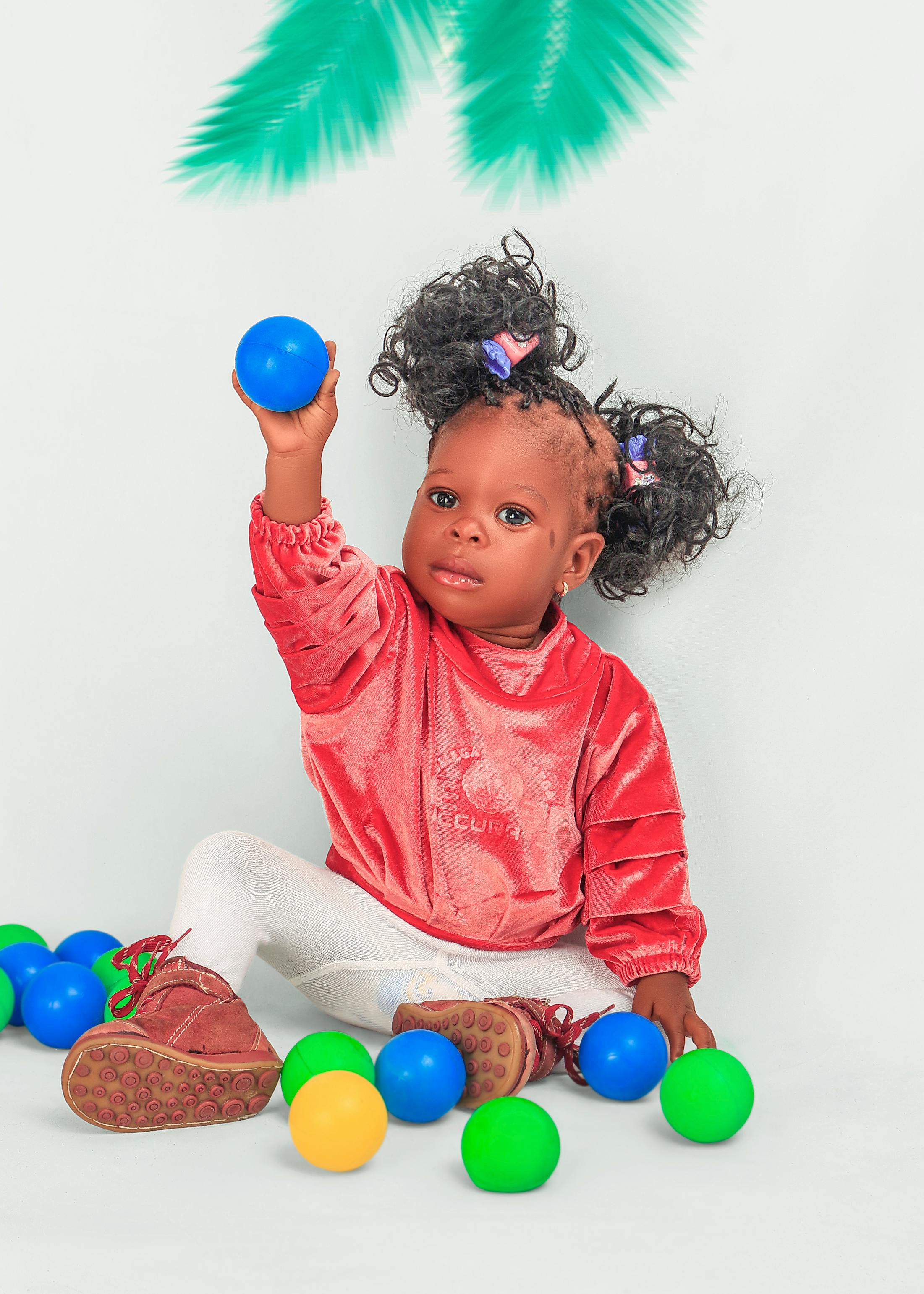 Girl in Purple Sweater Playing Beside Potted Plants · Free Stock Photo