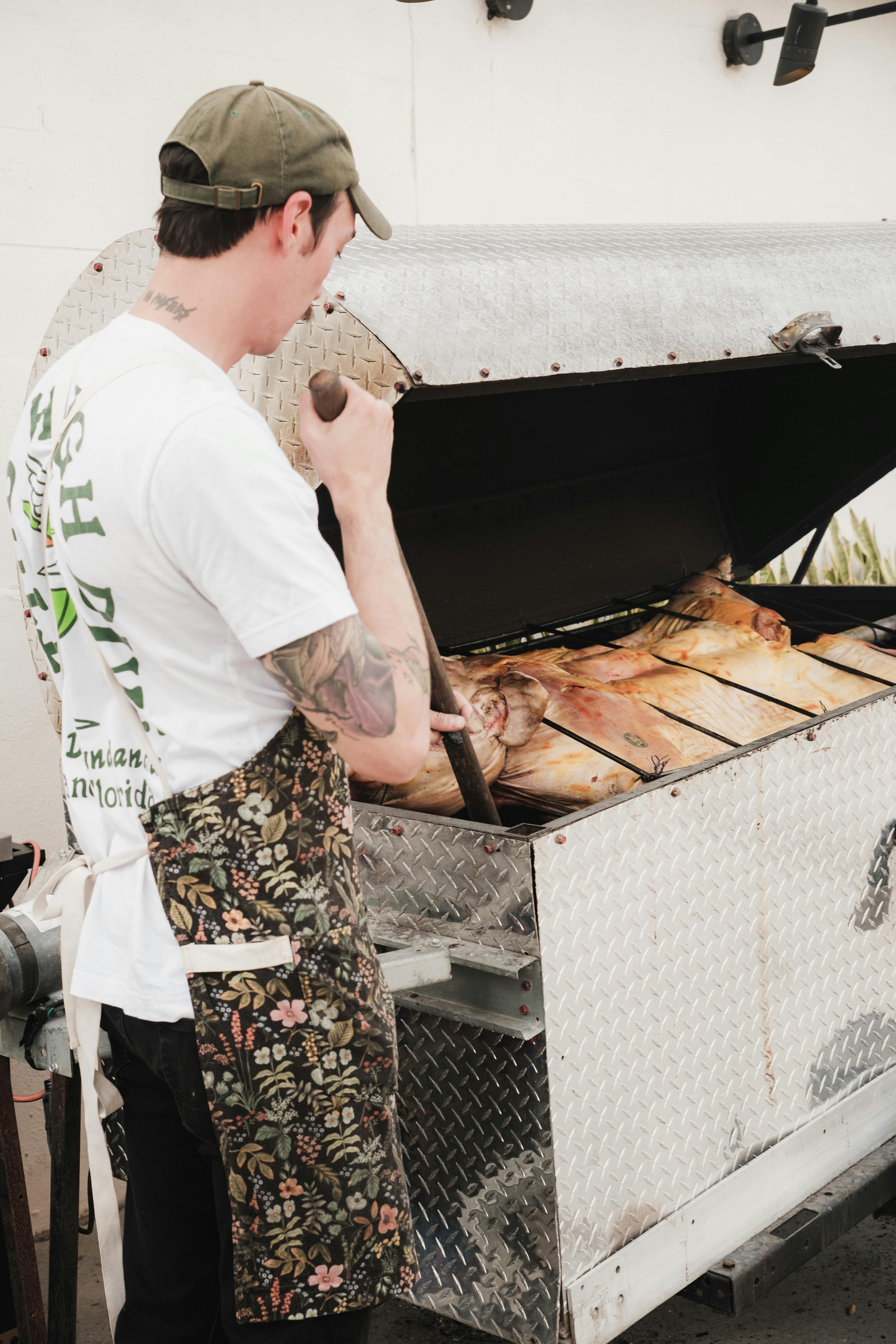Butcher Standing over Container with Meat · Free Stock Photo