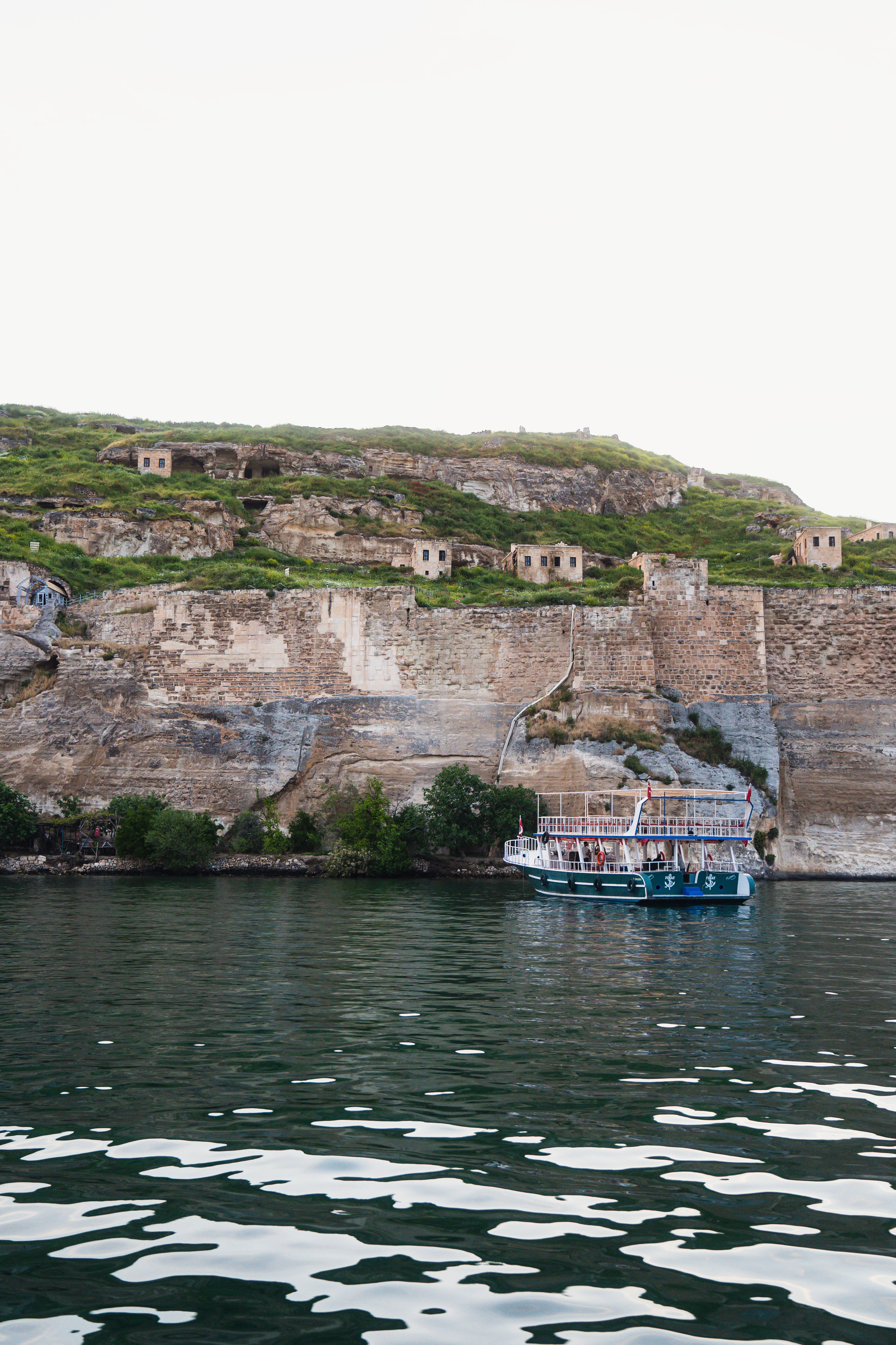 Passenger Ship under Wall and Village Ruins on Sea Coast · Free Stock Photo