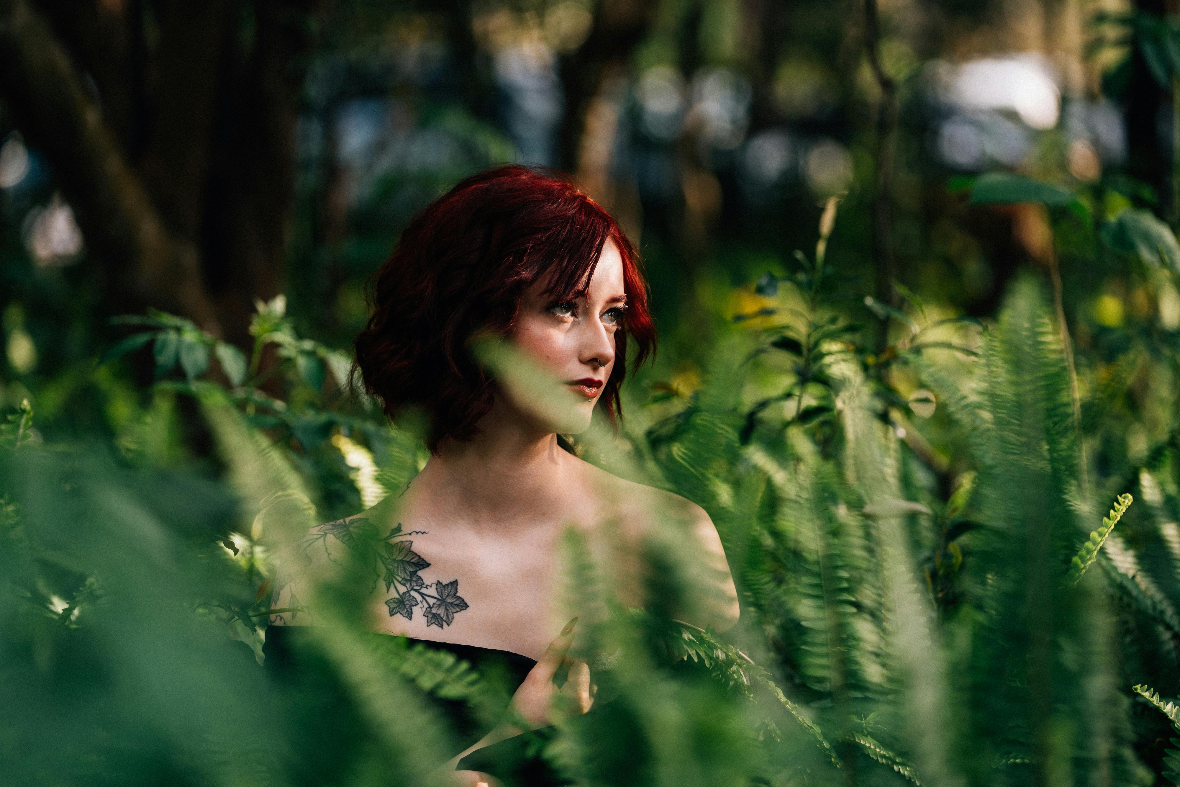 Redhead Woman Standing among Tall Ferns · Free Stock Photo