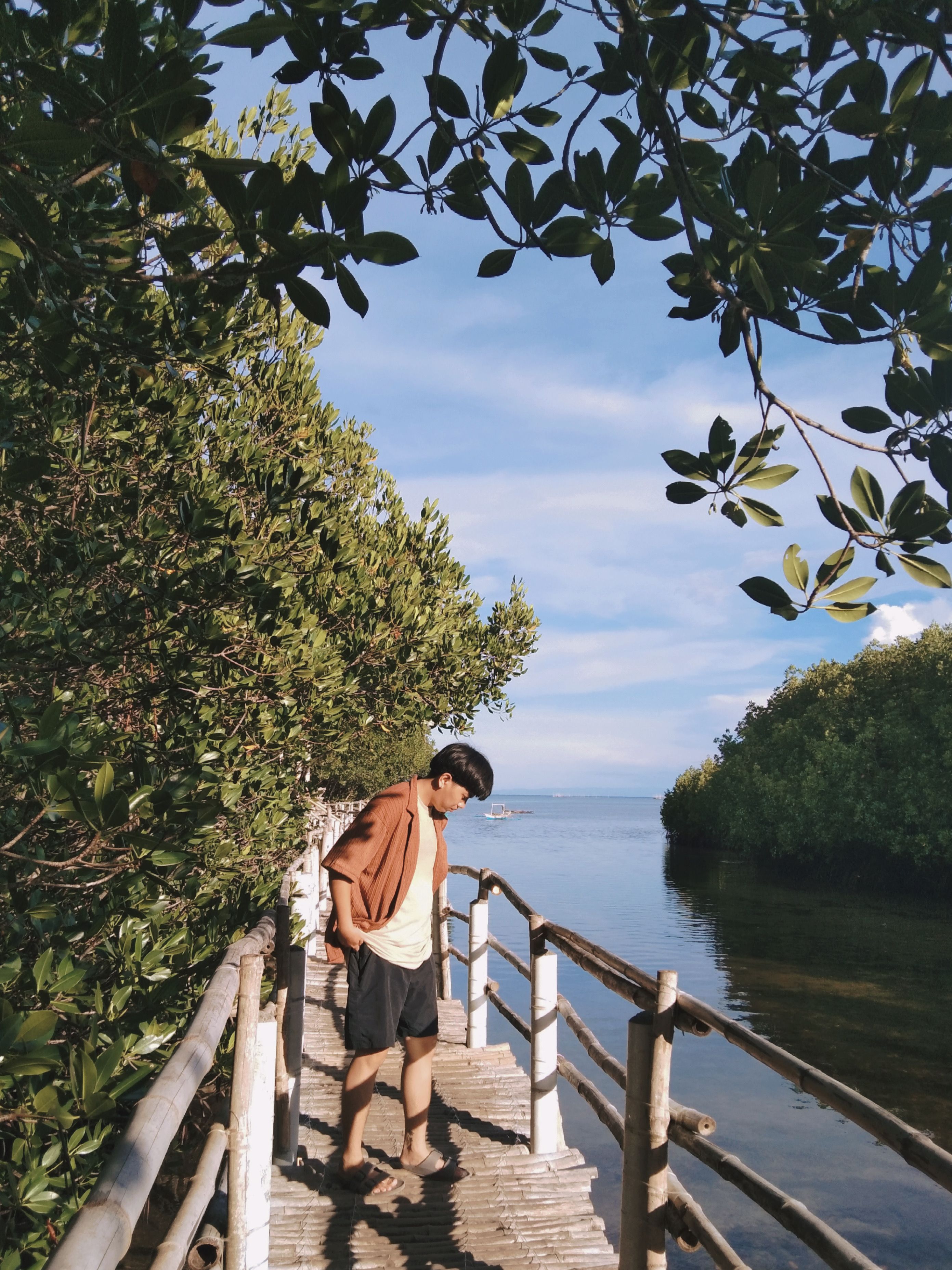Man Standing on Boardwalk on Seashore · Free Stock Photo