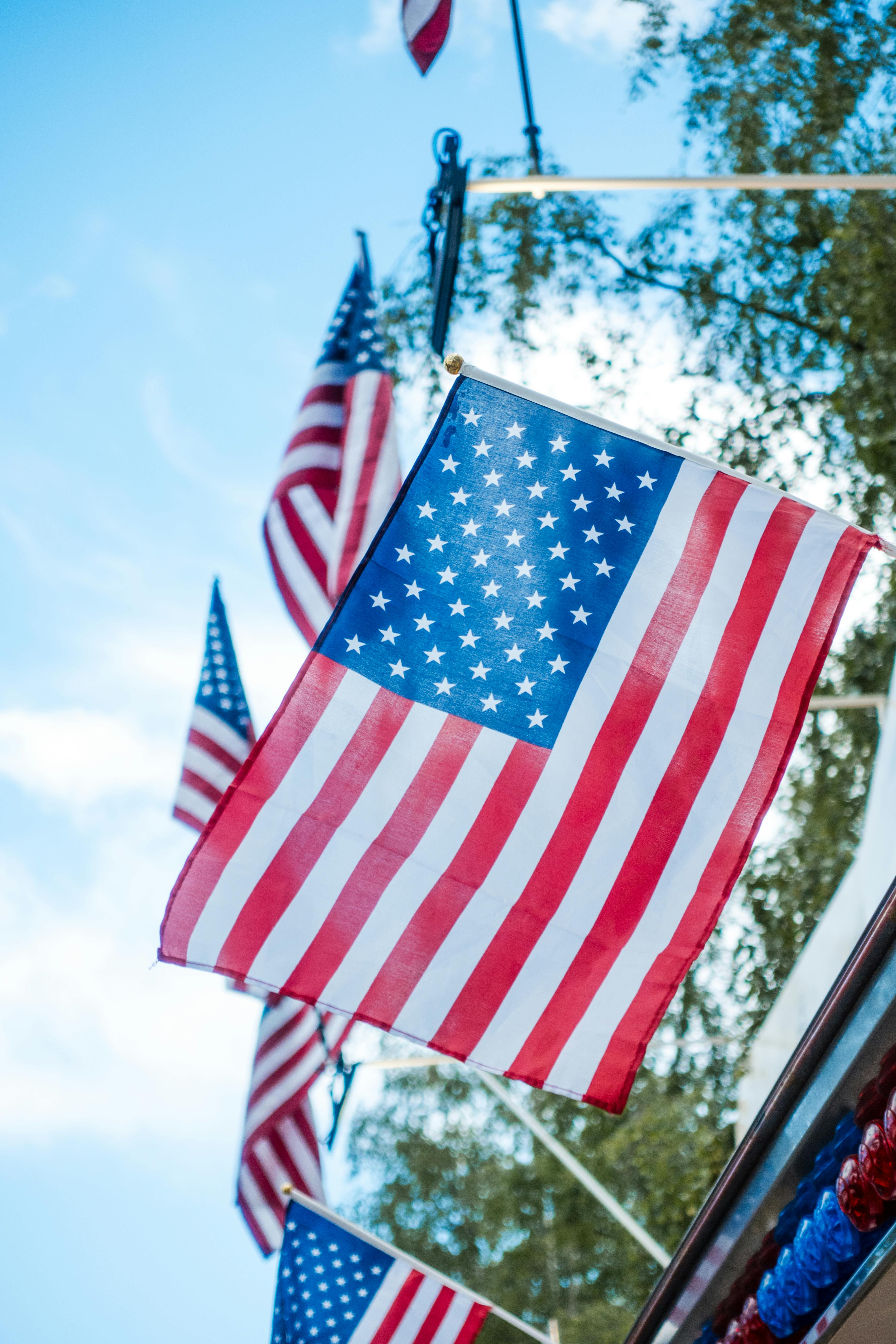 American flags hanging from a pole in front of a blue sky · Free Stock ...