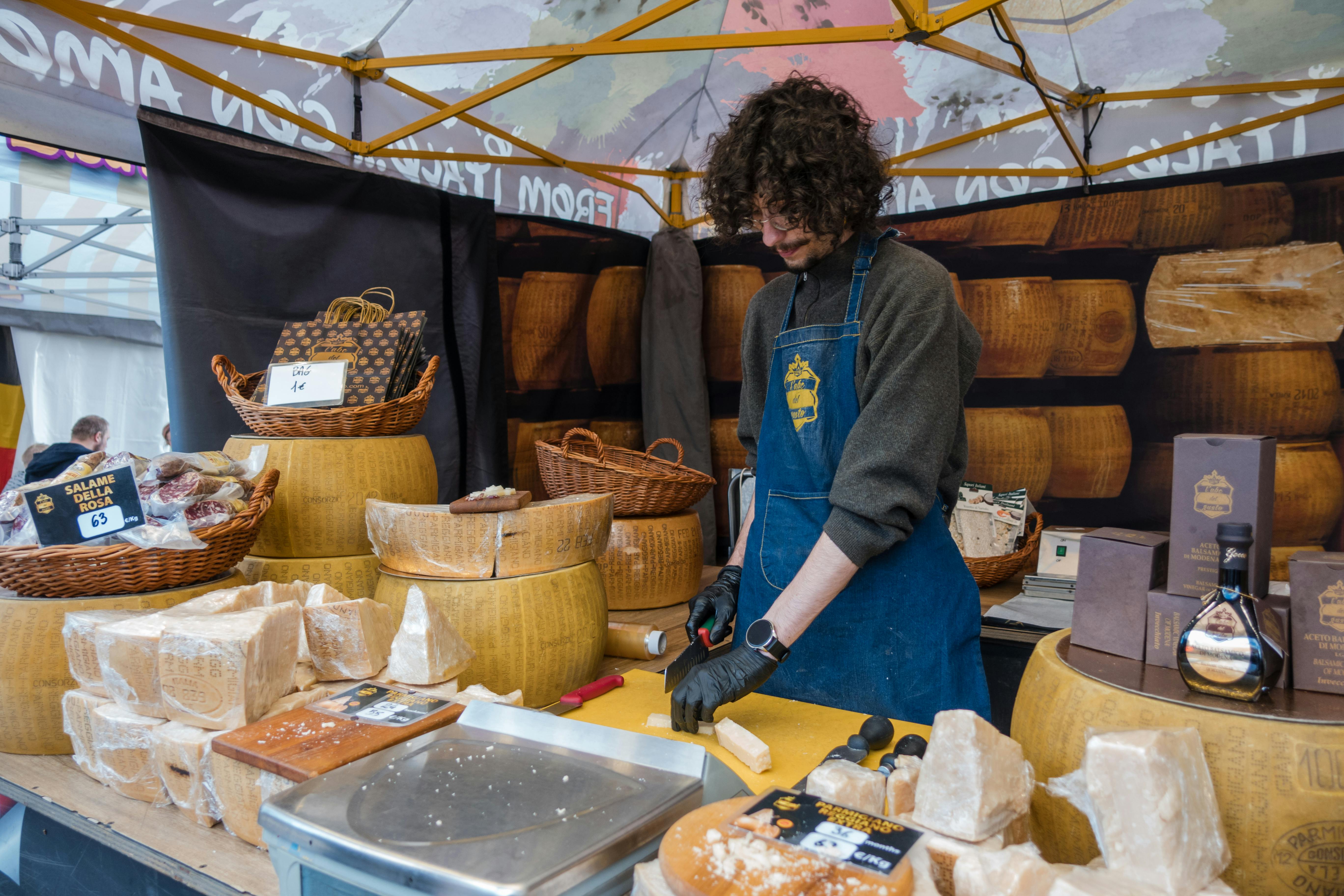 Young Man Selling a Variety of Cheeses · Free Stock Photo